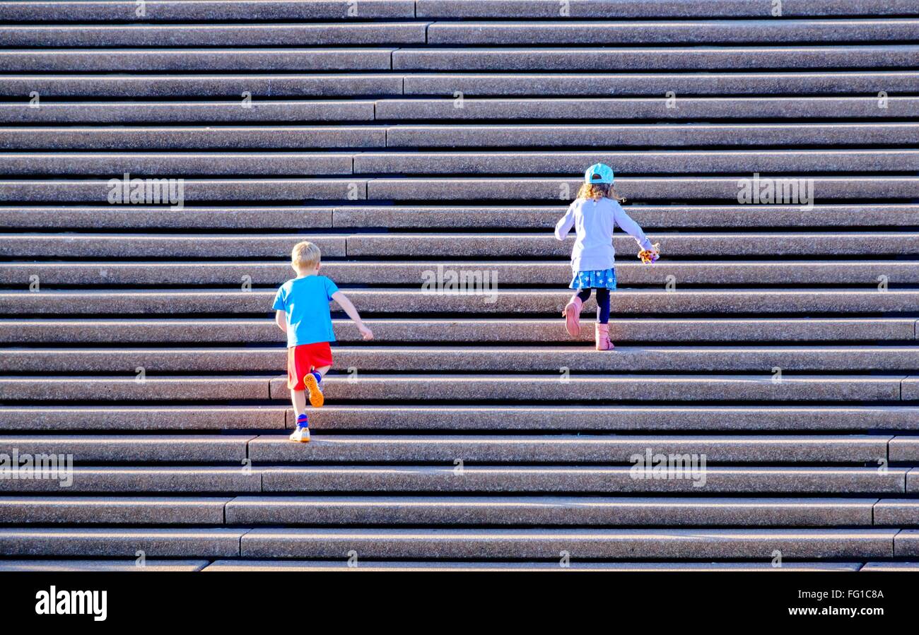Rear View Of Children Climbing Up Steps Stock Photo - Alamy