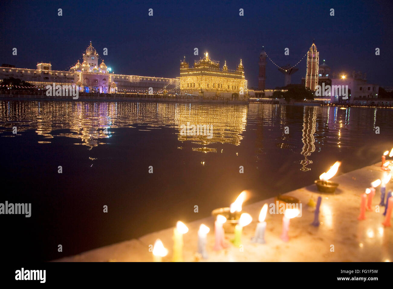 Lighting candles at pond surrounding Hari Mandir Sahib swarn mandir or ...