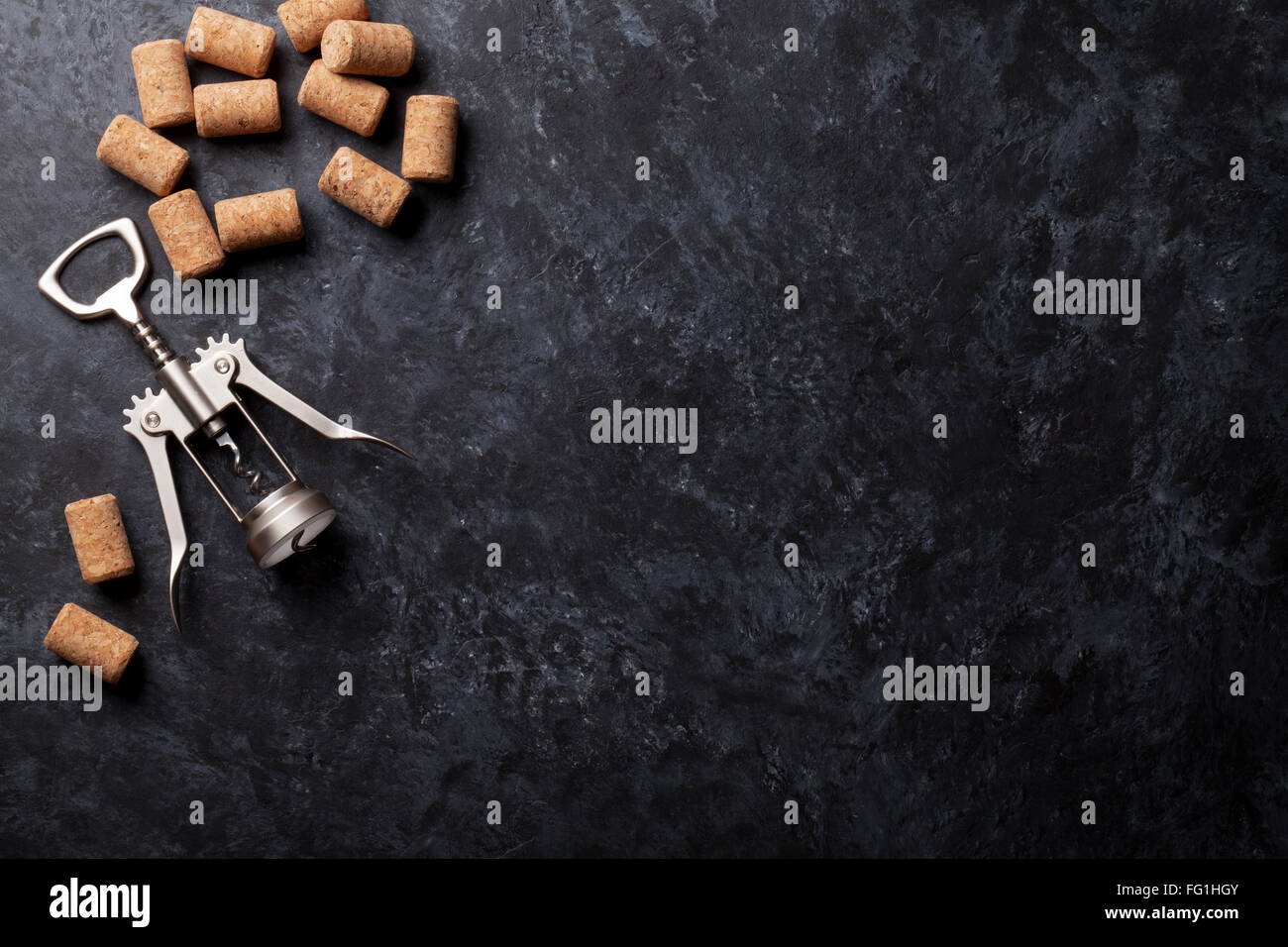 Wine corks and corkscrew over dark stone background. Top view with copy ...