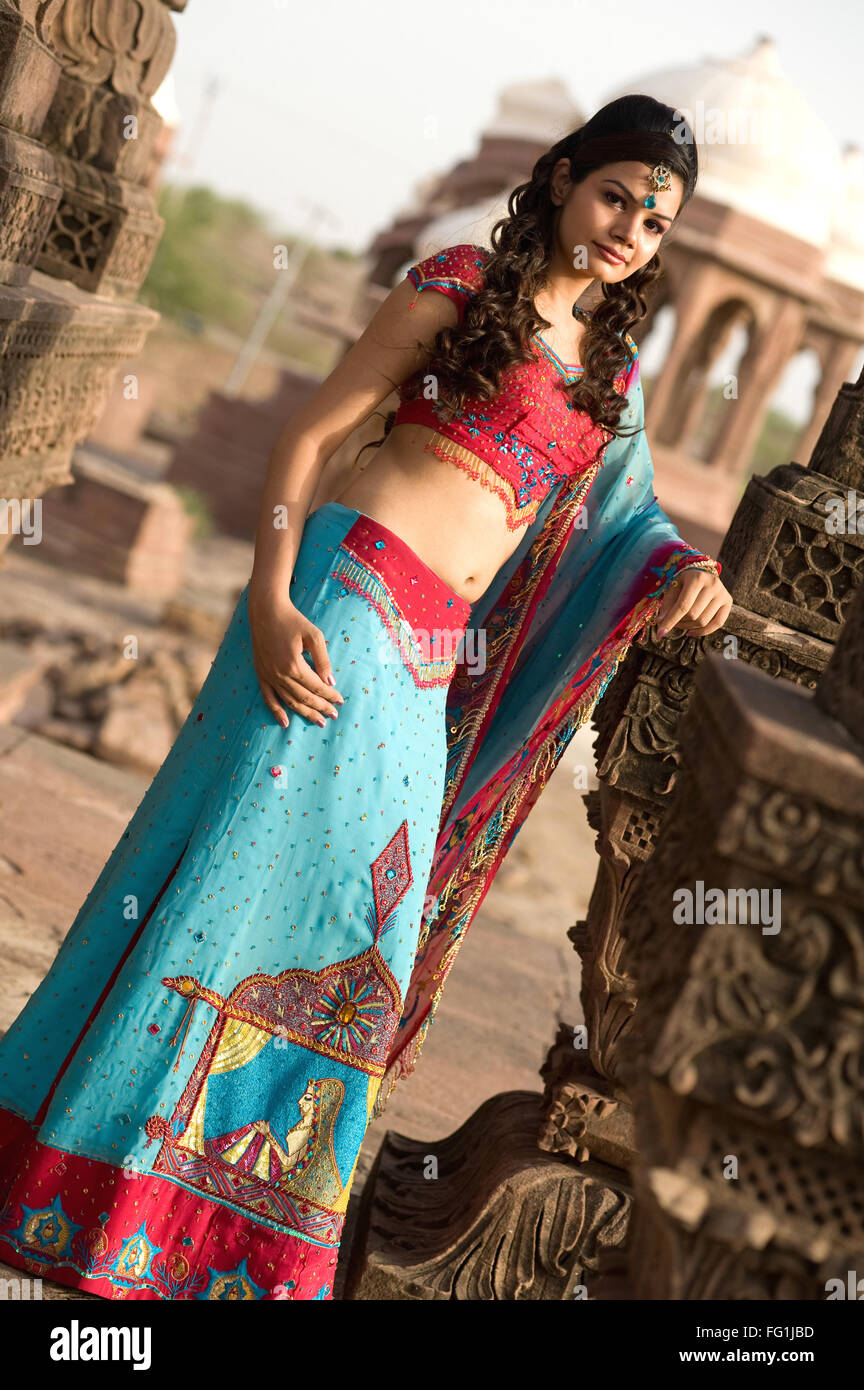 Lady in traditional wearing standing at heritage structure ; India MR ...