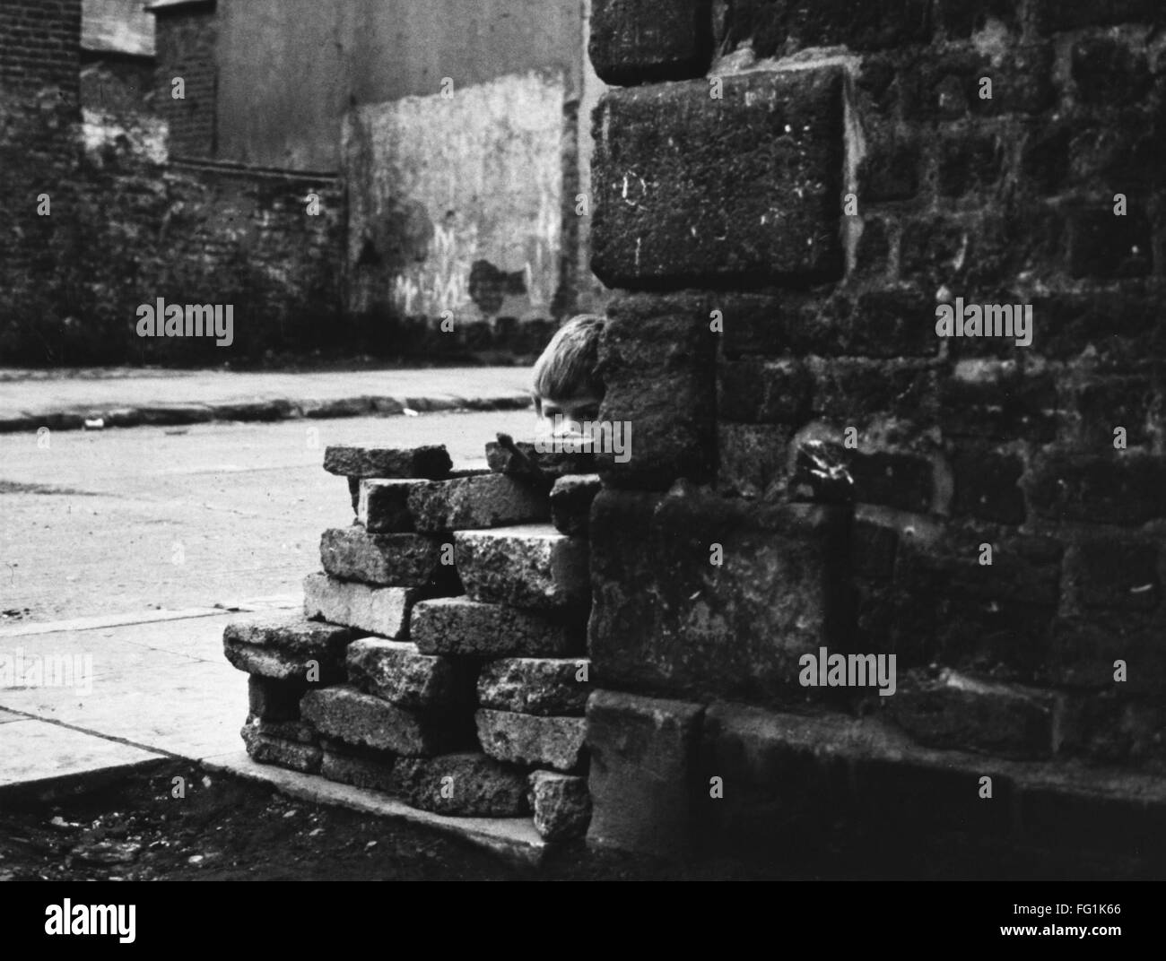 BELFAST: CHILD, 1971. /nA young boy hiding behind a barricade of bricks ...