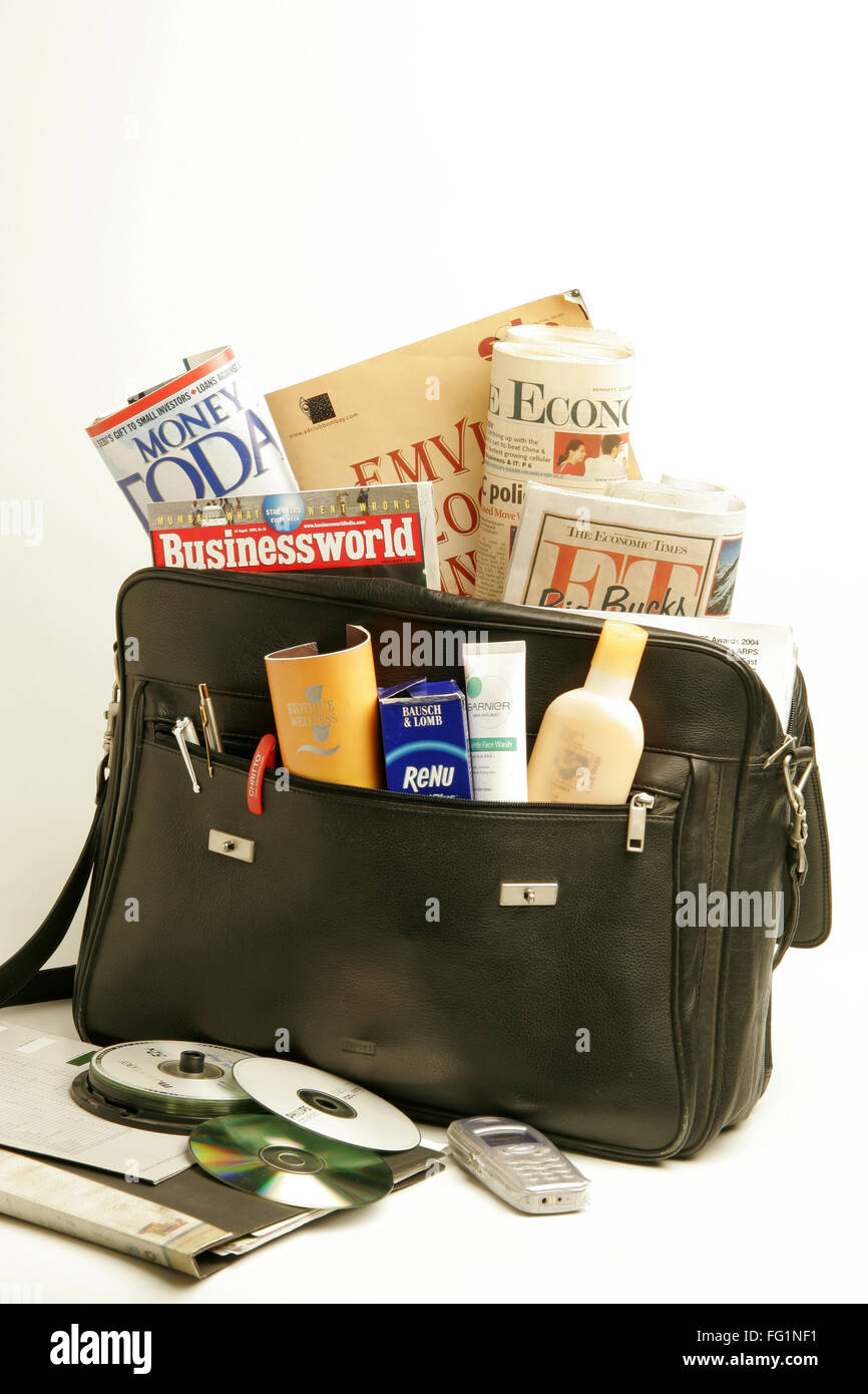 Black leather office bag filled with newspaper magazine beauty product ...