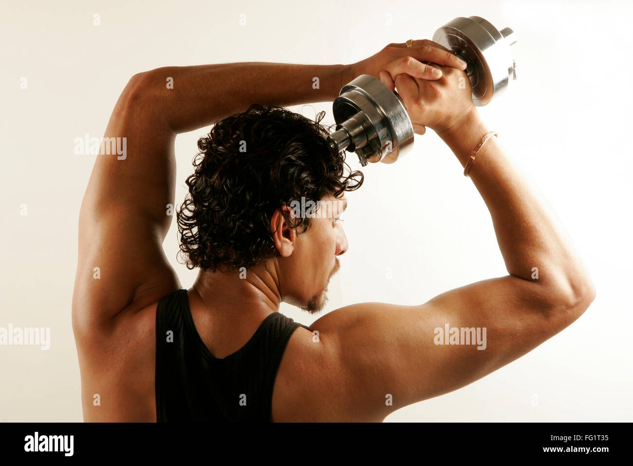 South Asian Indian man wearing black vest and curly oily hair building ...