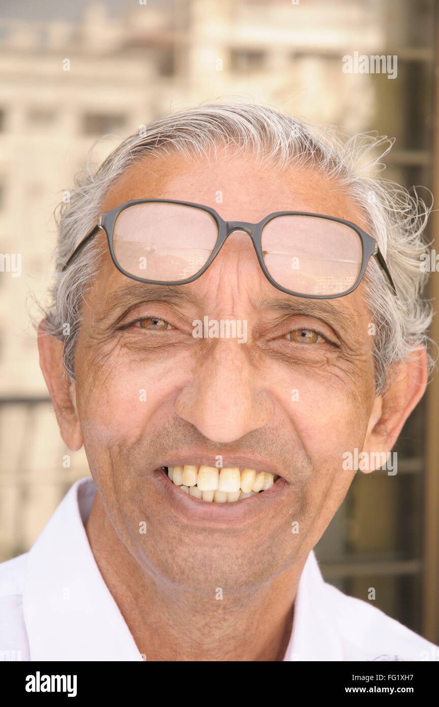 Sixty four year old man wearing spectacles over his forehead MR#686N ...