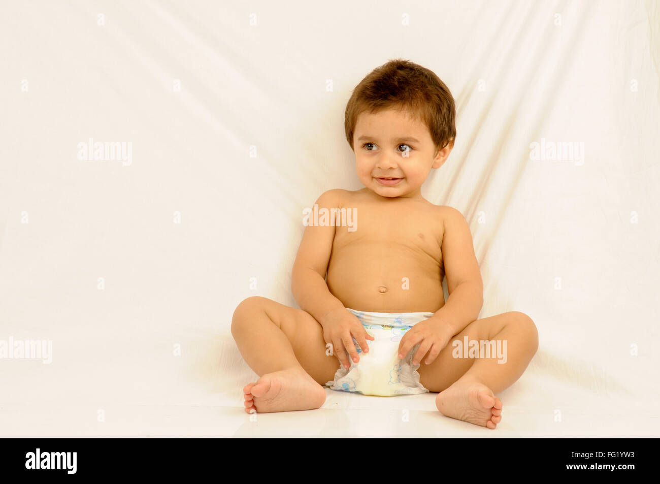 One year old boy in nappy resting on white background of cloth MR#686O ...