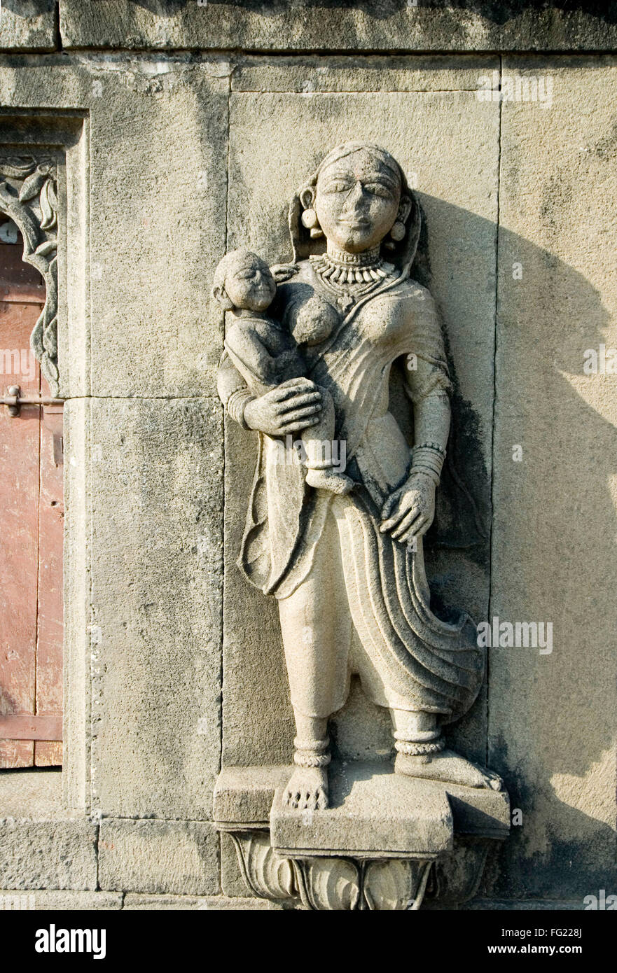 Woman with child carved in stone on wall of Maheshwar temple ...