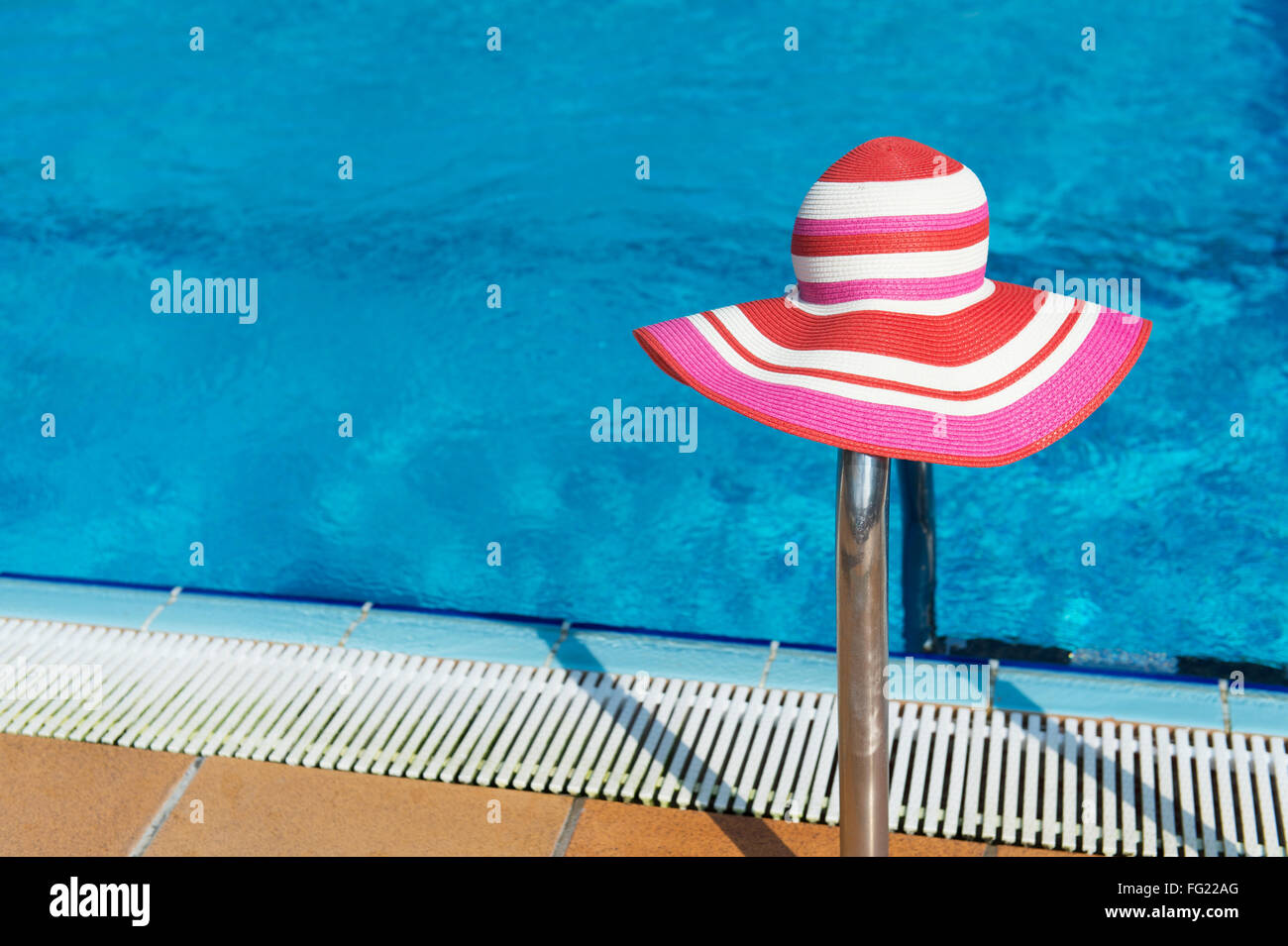 Luxury swimming pool with pink female sun hat Stock Photo - Alamy