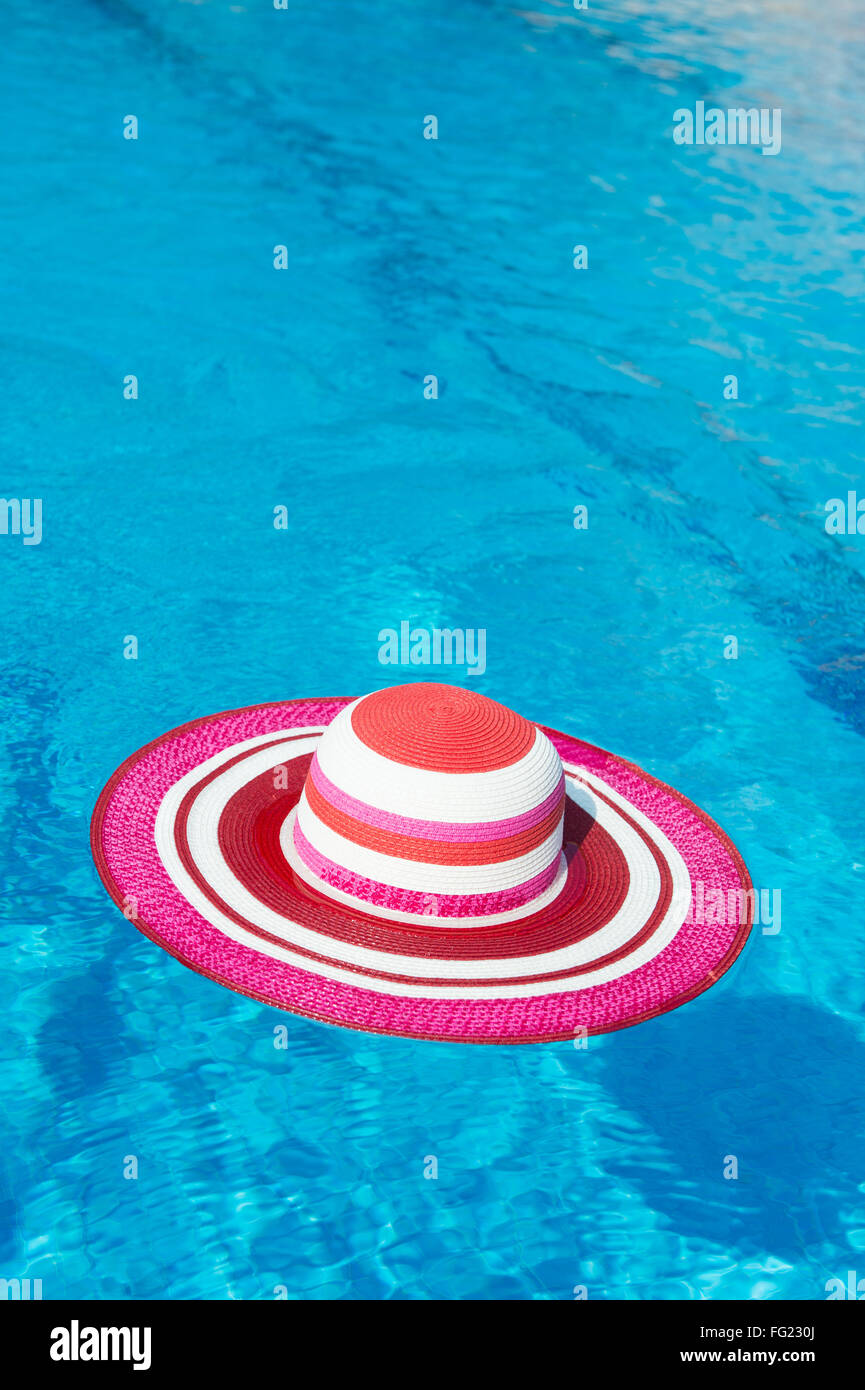 Luxury swimming pool with pink female sun hat Stock Photo - Alamy