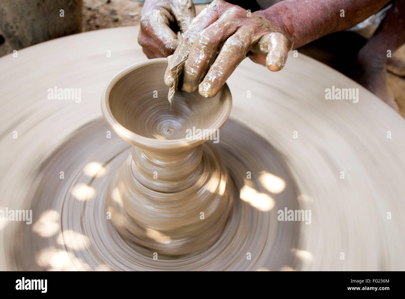 Potter hand making clay diva or panti on wheel Stock Photo - Alamy