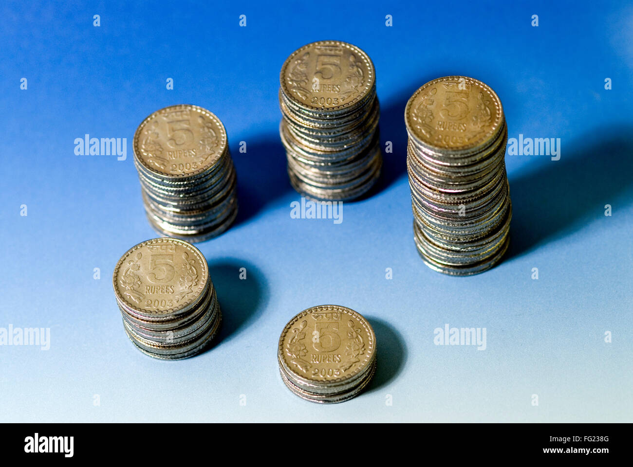 Concept , growth Indian five rupees coins arrange in stack on blue ...