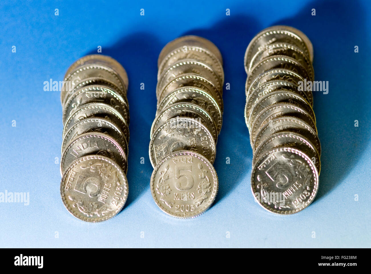 Concept , growth Indian five rupees coins arrange in row on blue white ...