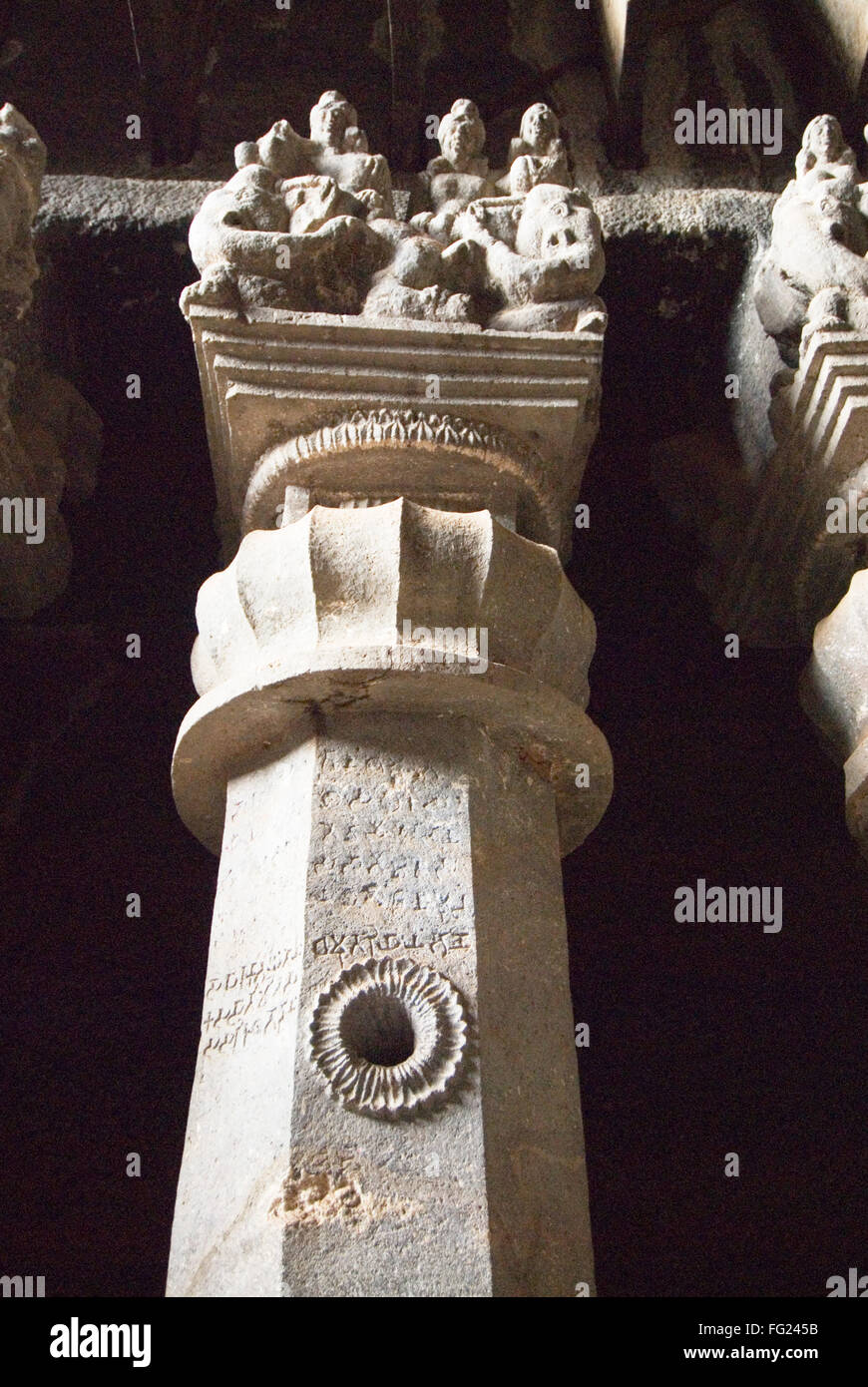 Decorative pillars and scripture in pali of Karla rock cut cave near ...