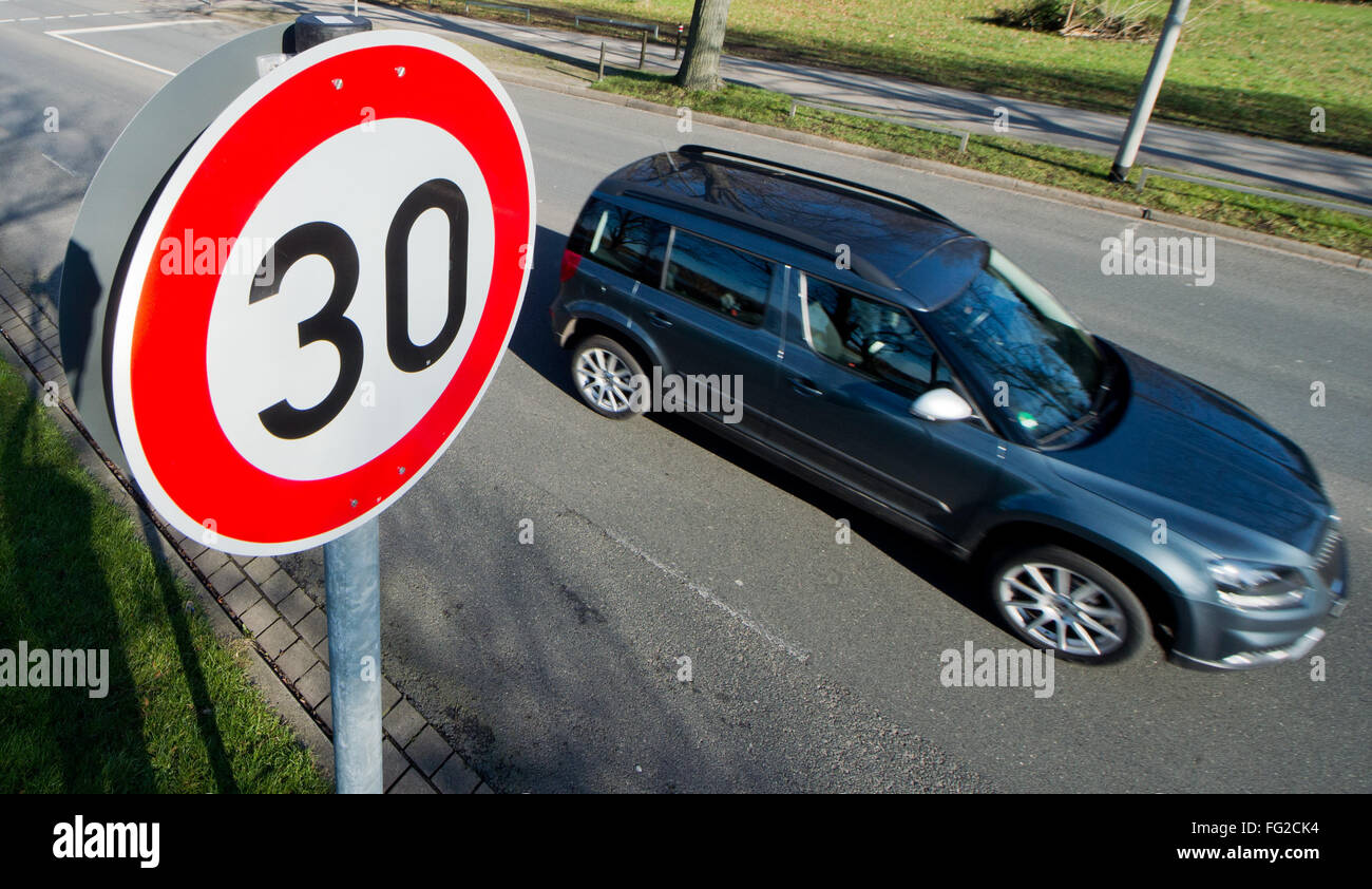 A car drives past a road sign which indicates a speed limit of 30 ...