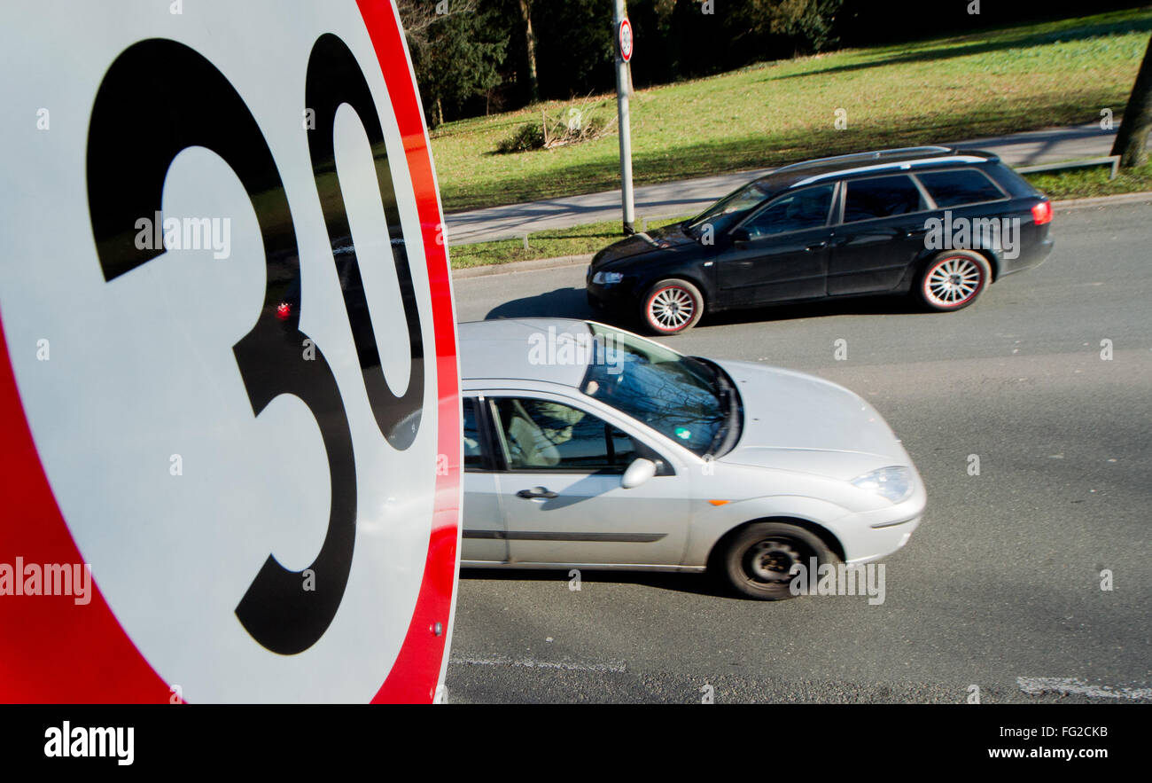 A car drives past a road sign which indicates a speed limit of 30 ...