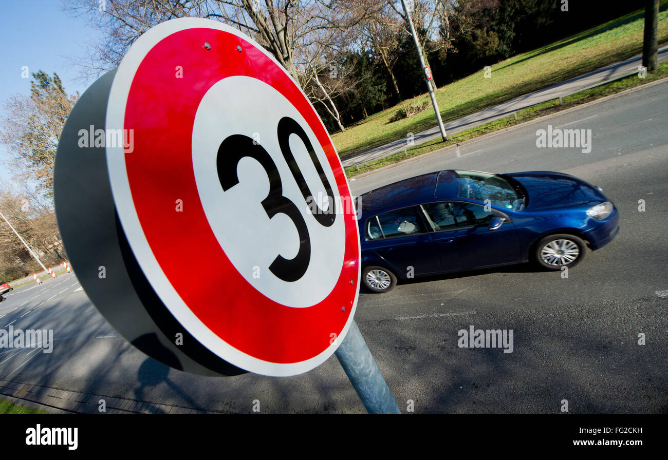A car drives past a road sign which indicates a speed limit of 30 ...