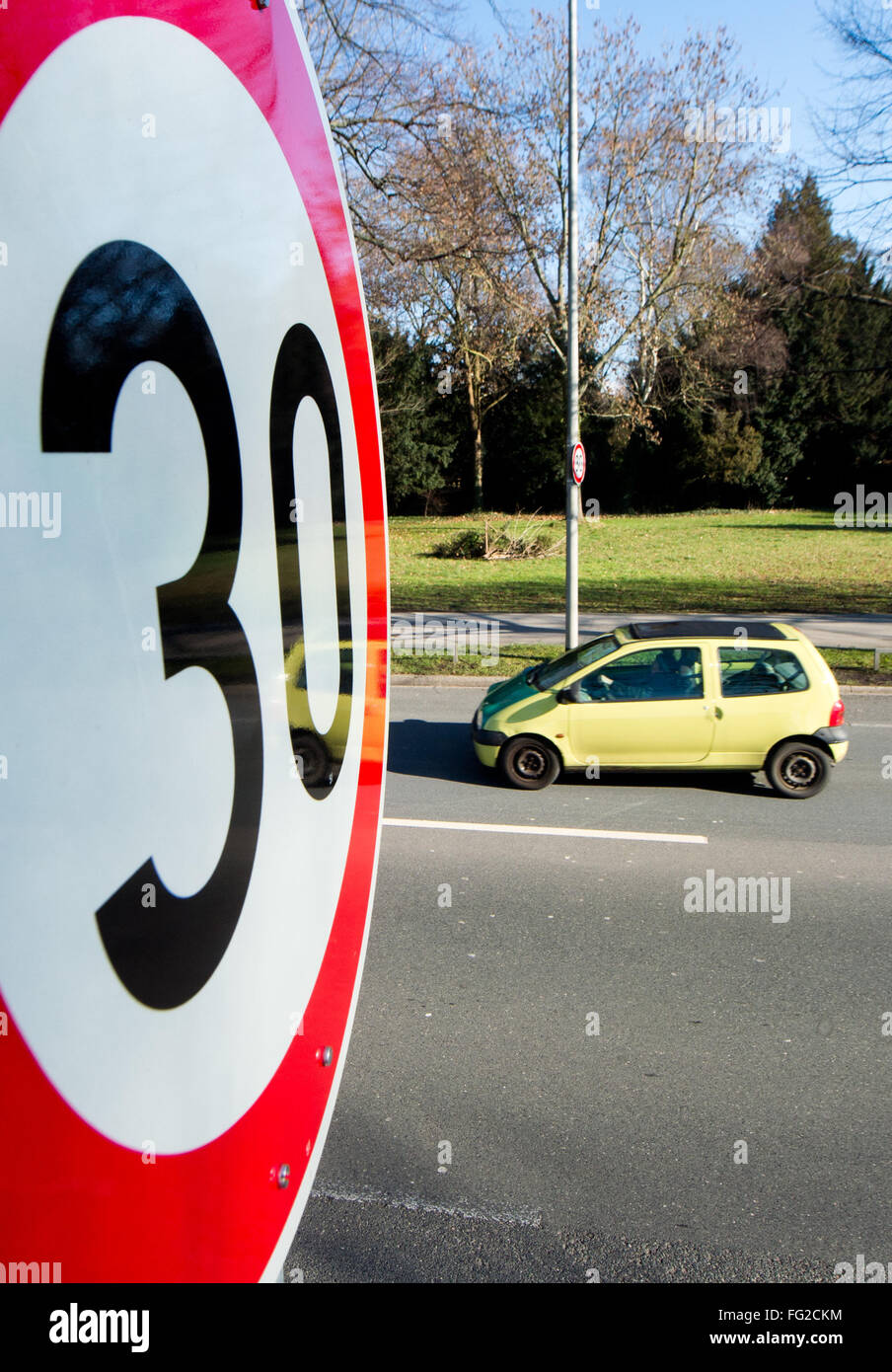 A car drives past a road sign which indicates a speed limit of 30 ...