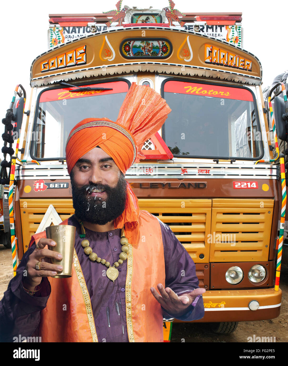 Sikh man holding glass of lassi standing in front of lorry MR#779C ...