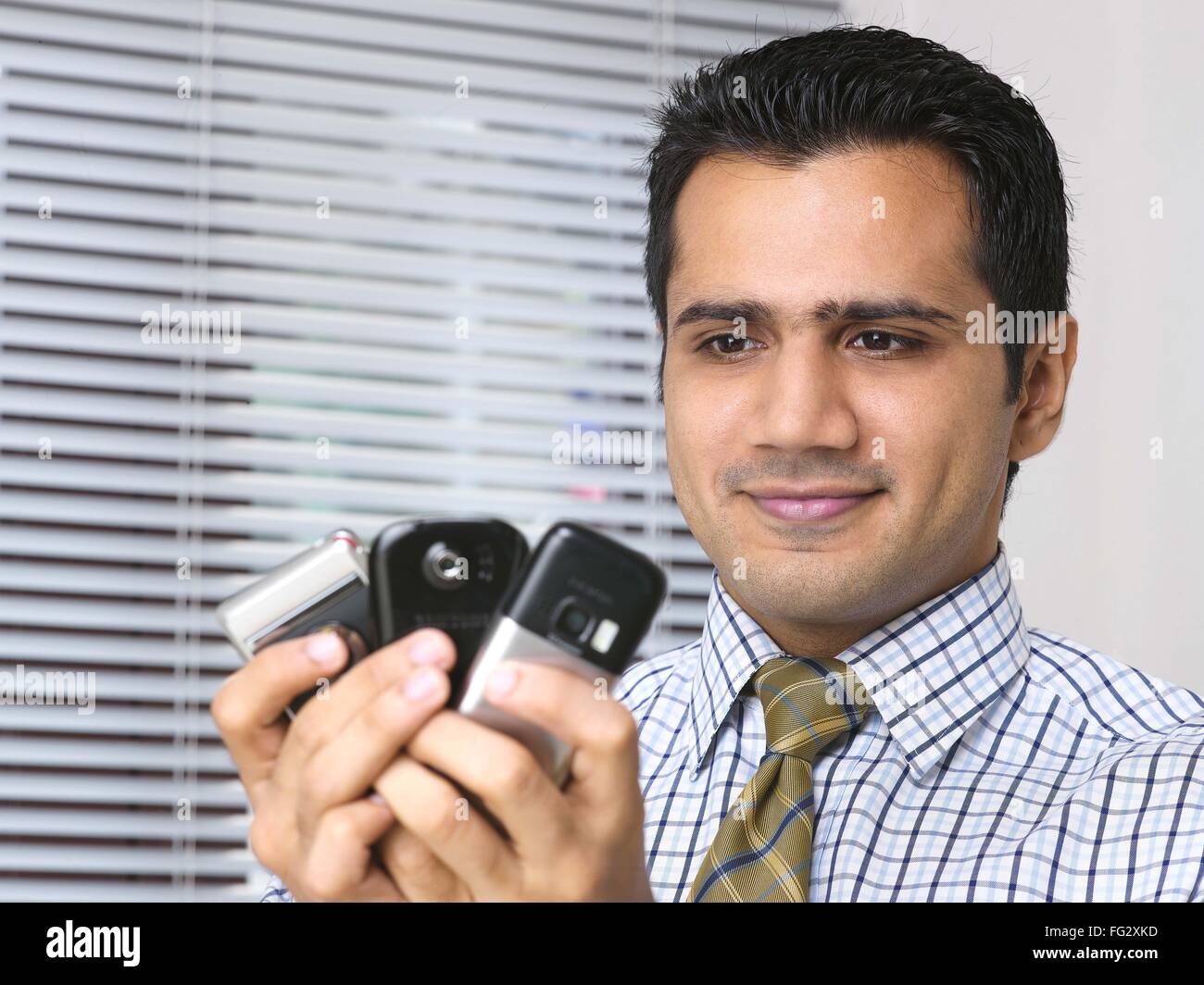 Many hand holding mobile phones hi-res stock photography and images - Alamy