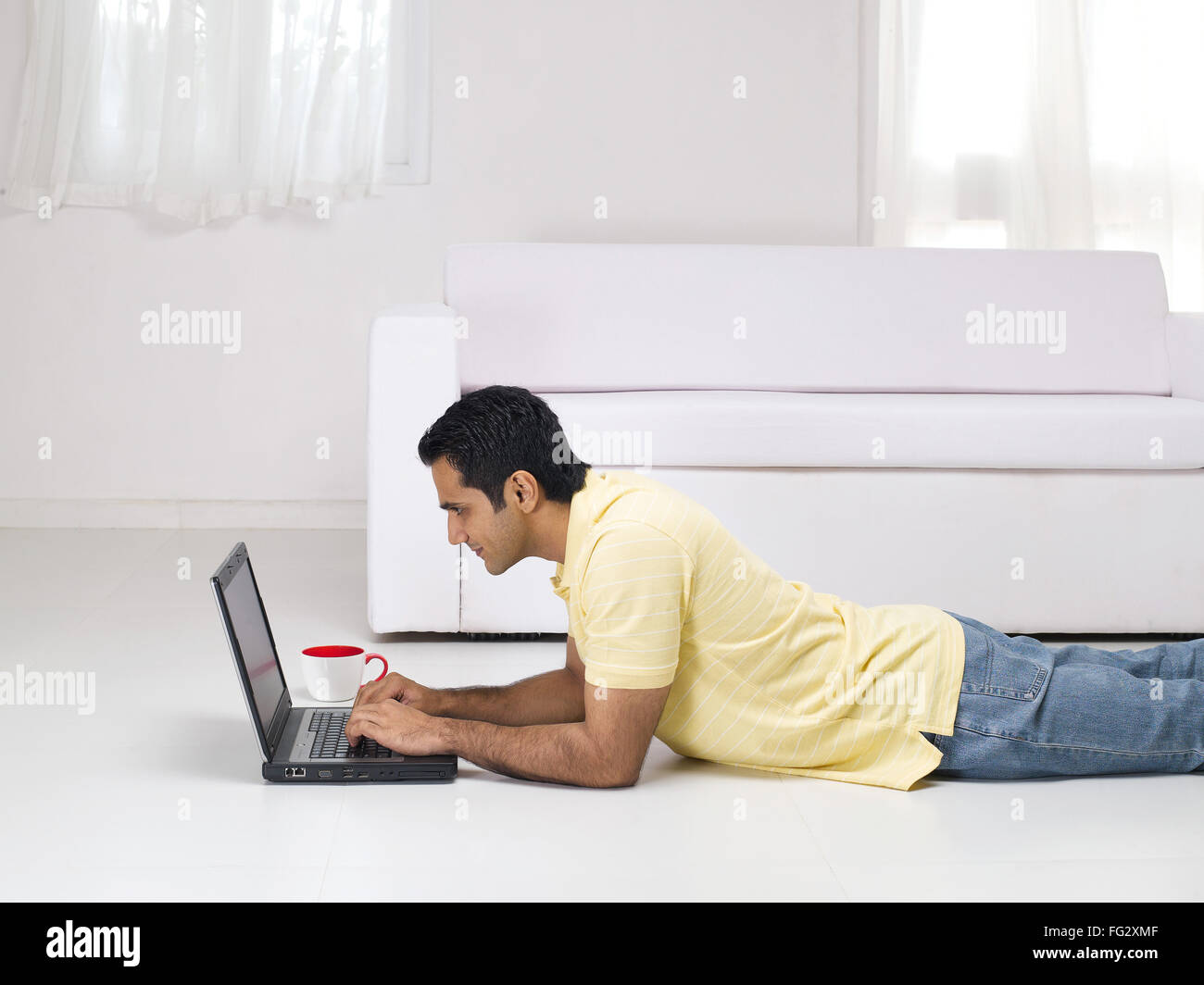 Man laying on floor using laptop MR#779K Stock Photo - Alamy