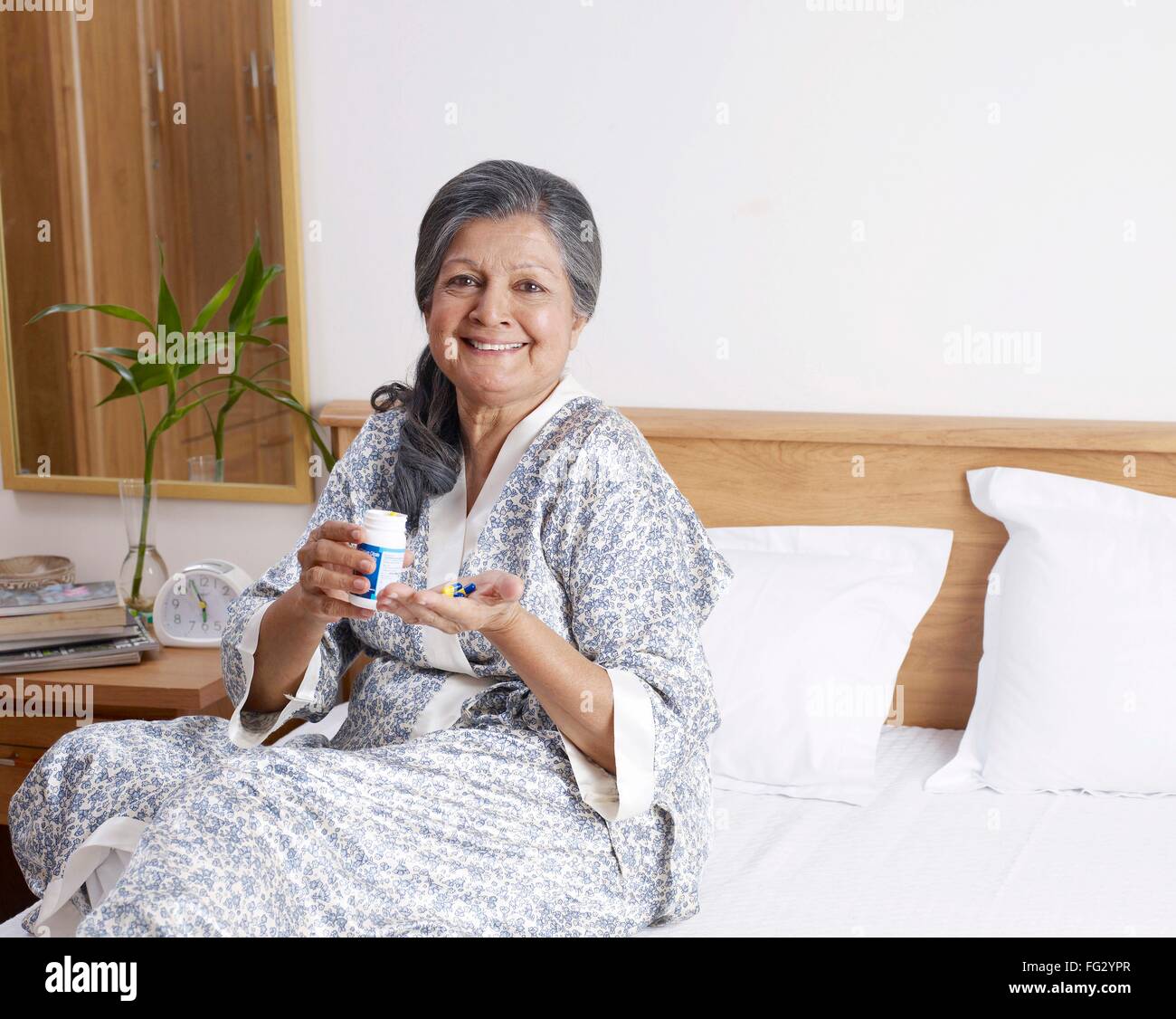 Old lady holding bottle pills on hand palm sitting on bed MR#702S Stock ...