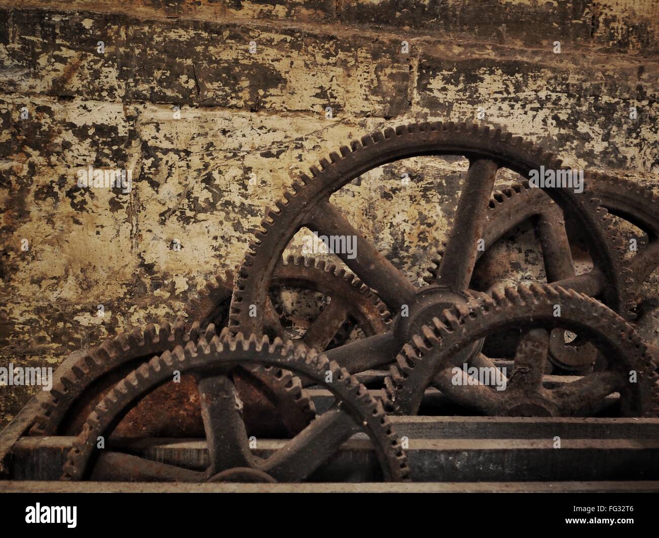 Old Metal Wheels Against Weathered Stock Photo - Alamy
