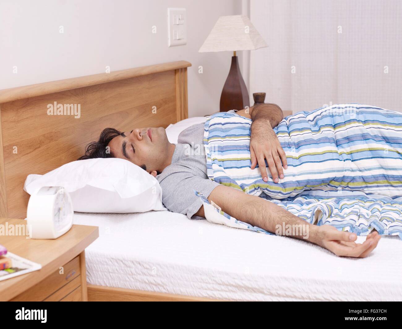 Young man having sound asleep on bed MR#702V Stock Photo - Alamy