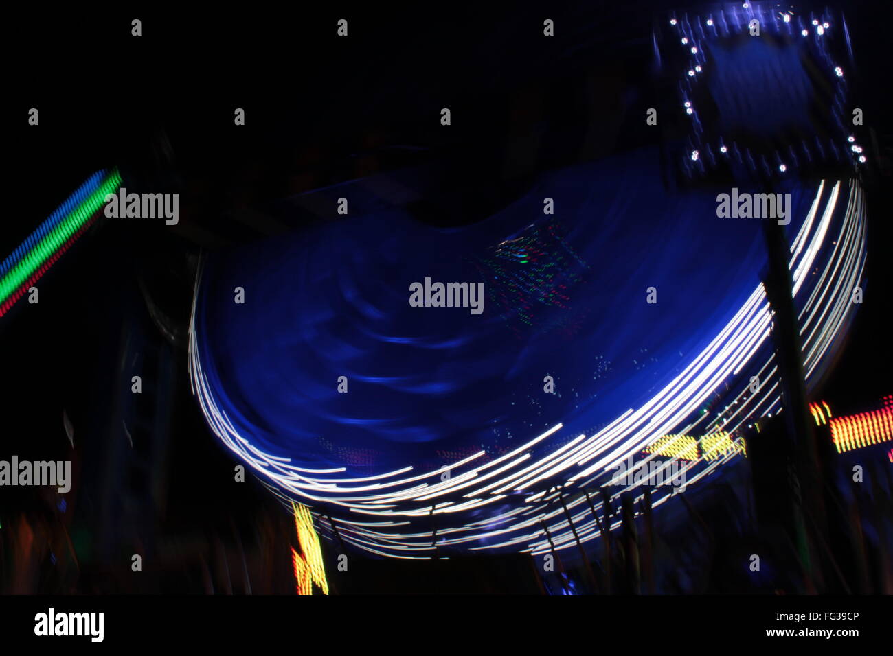 fairground funfair ride moving fast fair lights Night colours of the ...