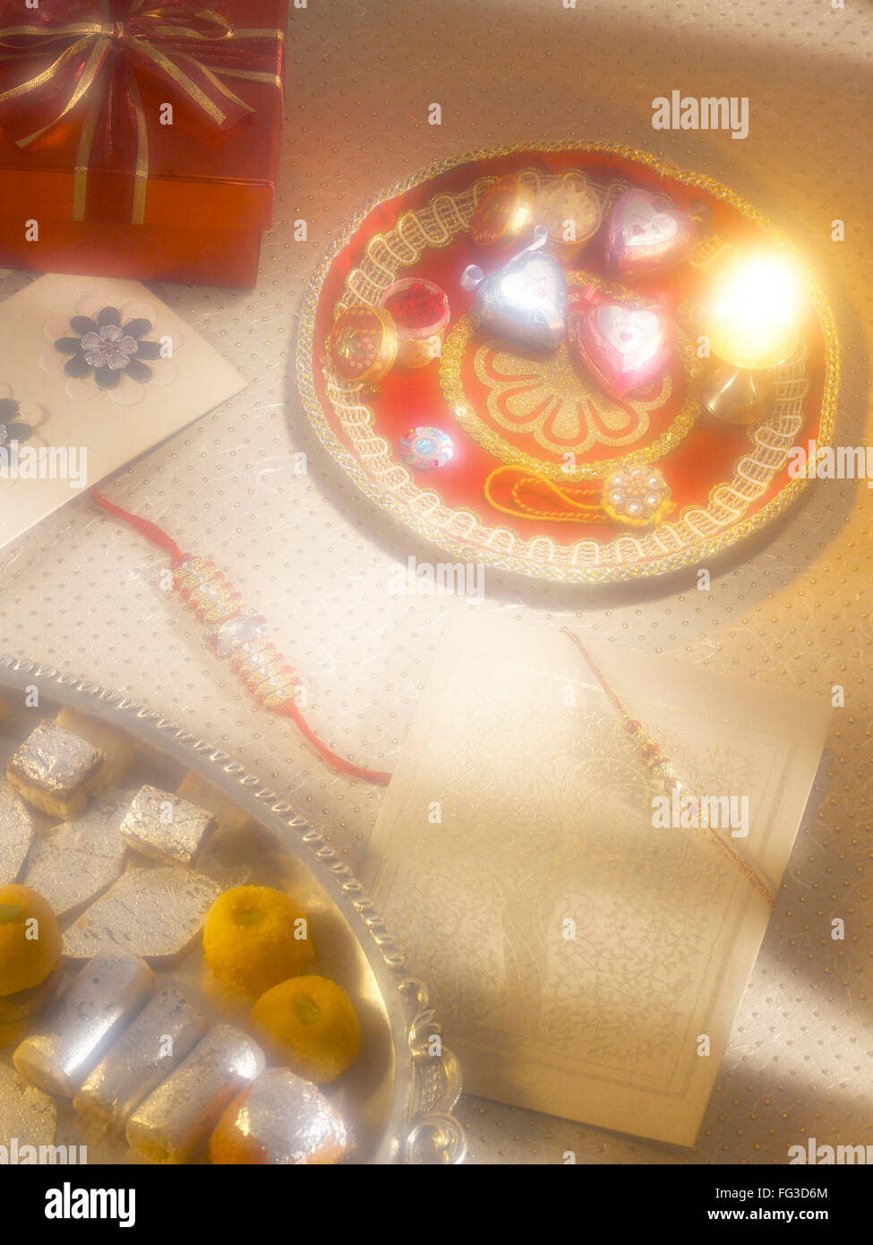 Rakhis sweets chocolates diya arrange in thali with gift box on ...