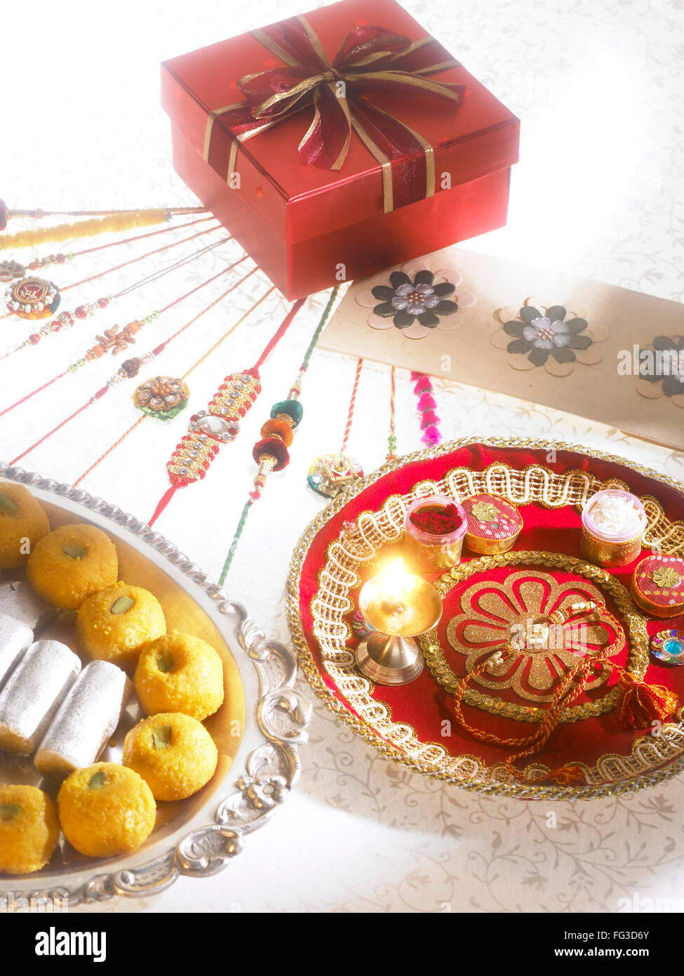 Rakhis sweets chocolates diya arrange in thali with gift box on ...