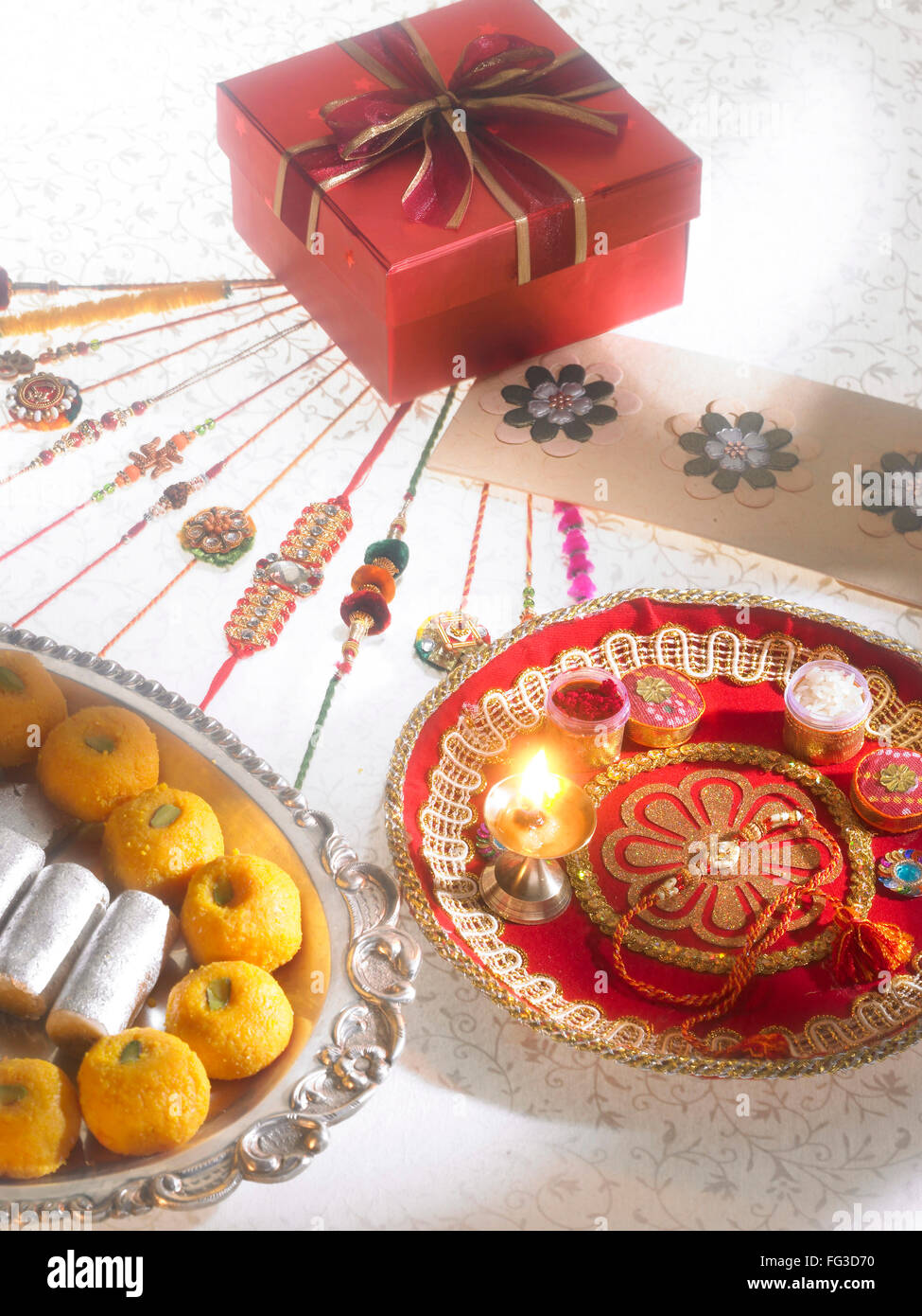 Rakhis sweets chocolates diya arrange in thali with gift box on ...