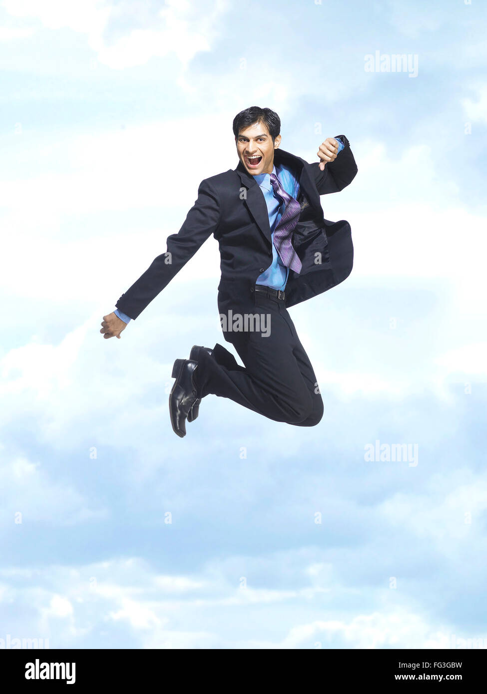 Executive jumping with joy in blue sky MR Stock Photo - Alamy