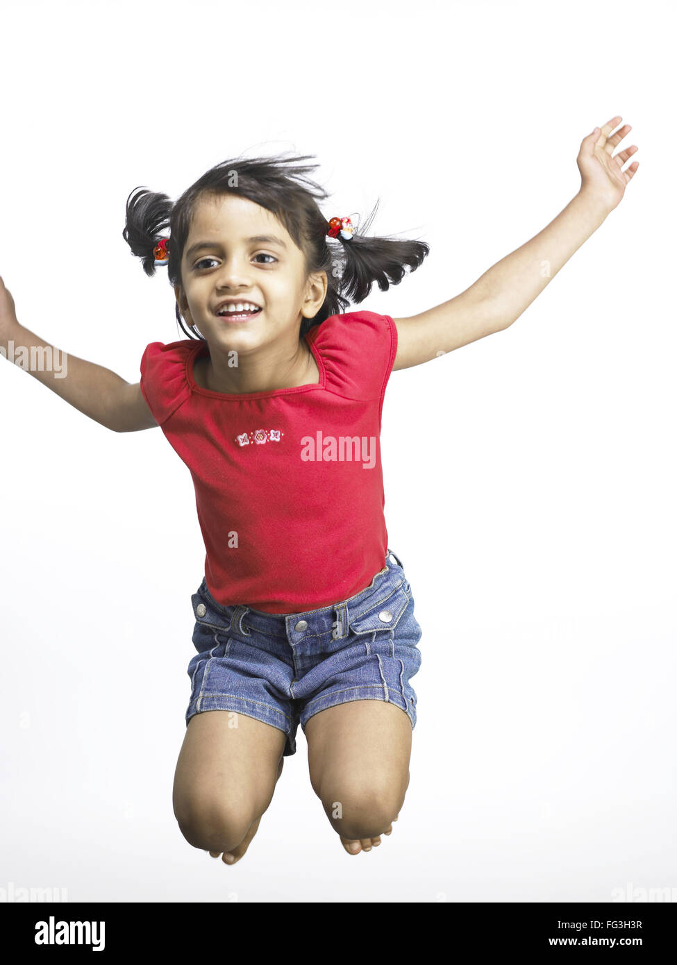 South Asian Indian girl jumping with joy in nursery school MR Stock ...