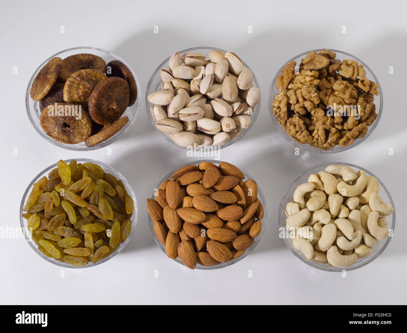 Dry fruits and nuts ; almonds pistachios walnuts raisins figs cashew nuts in bowls Stock Photo ...