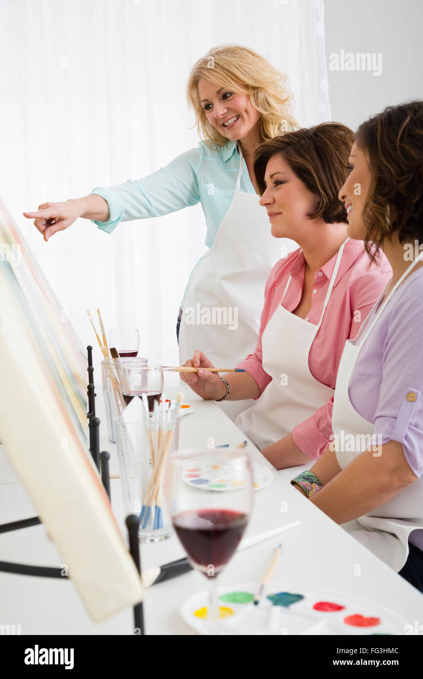 Three women talking while painting Stock Photo - Alamy