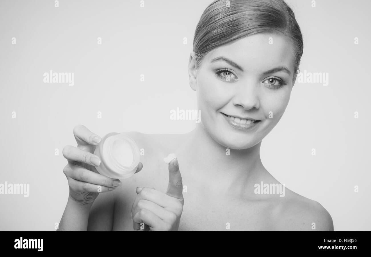 Woman applying moisturizing cream on her face. Female taking care of ...