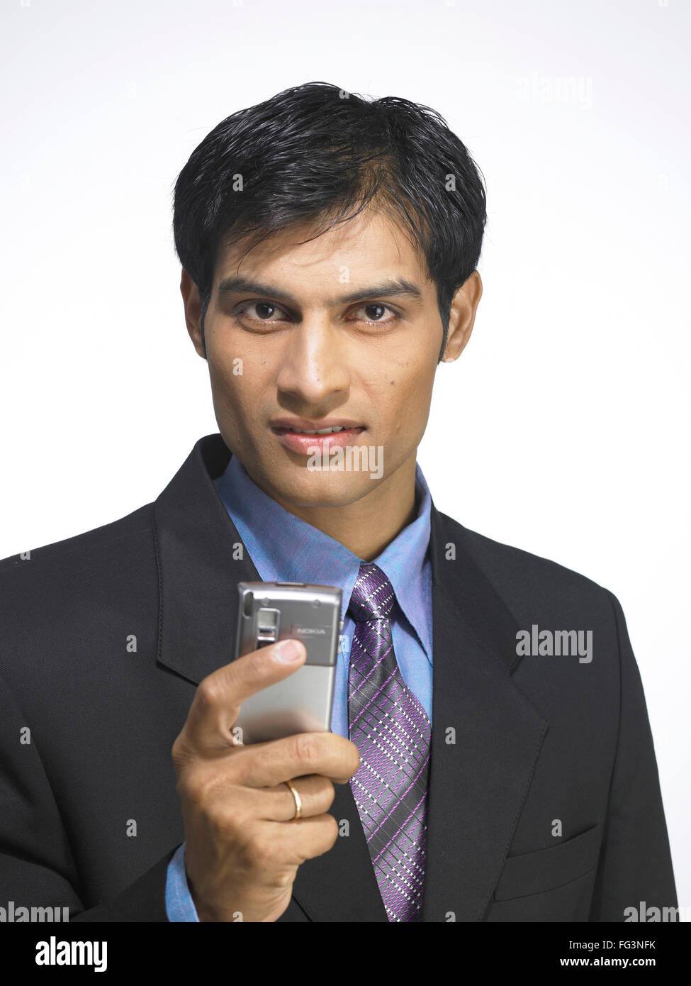 South Asian Indian executive man holding mobile phone MR Stock Photo ...