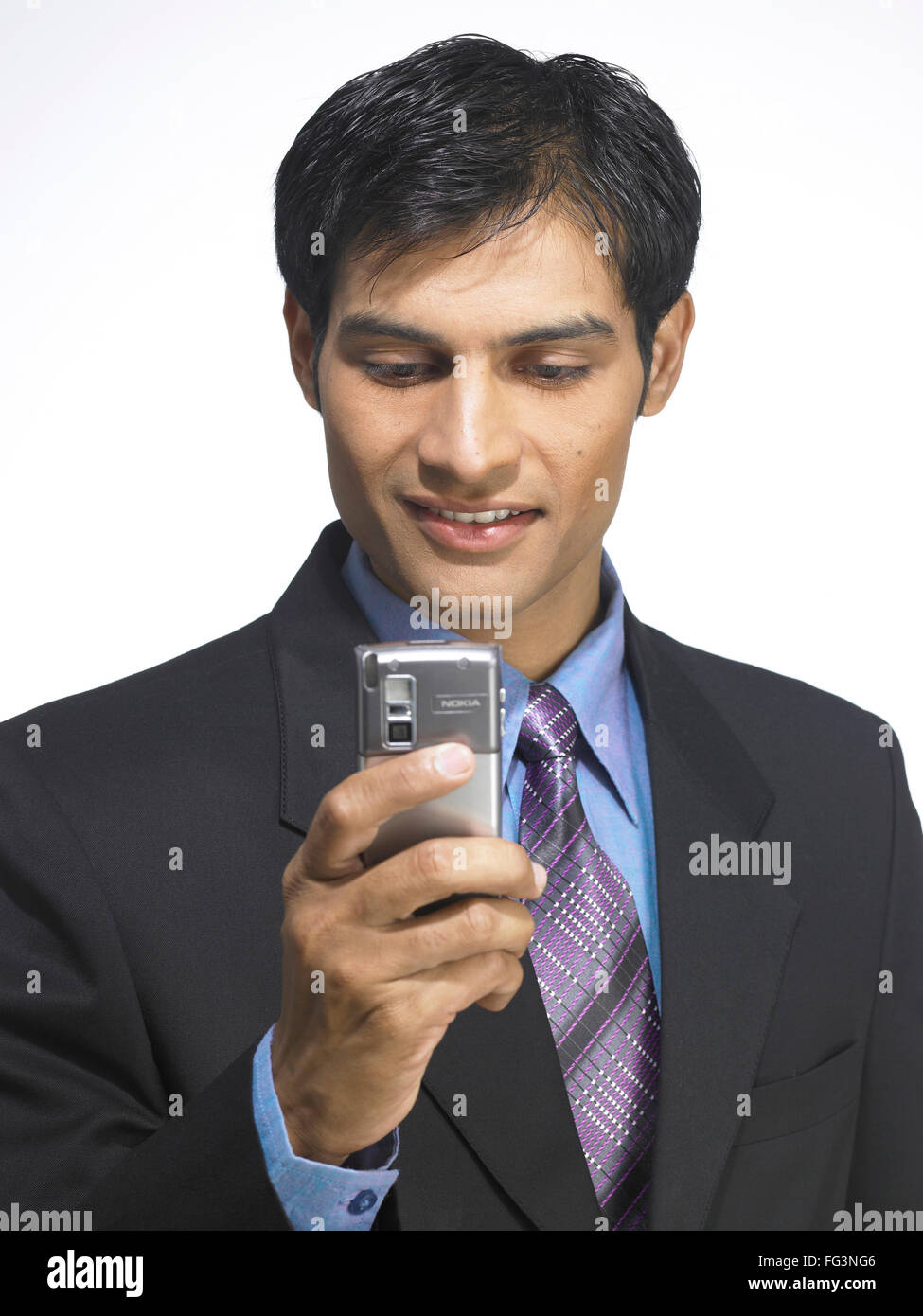 South Asian Indian executive man looking at mobile phone MR Stock Photo ...