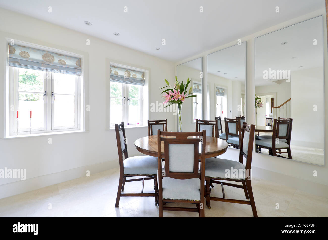 white dining room with mirrored wall Stock Photo - Alamy