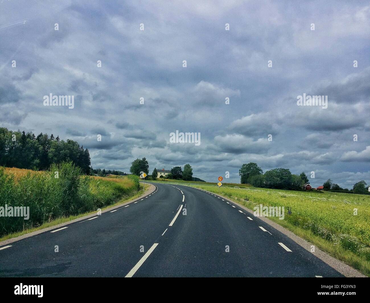 Empty Road Amidst Farms Against Cloudy Sky Stock Photo - Alamy