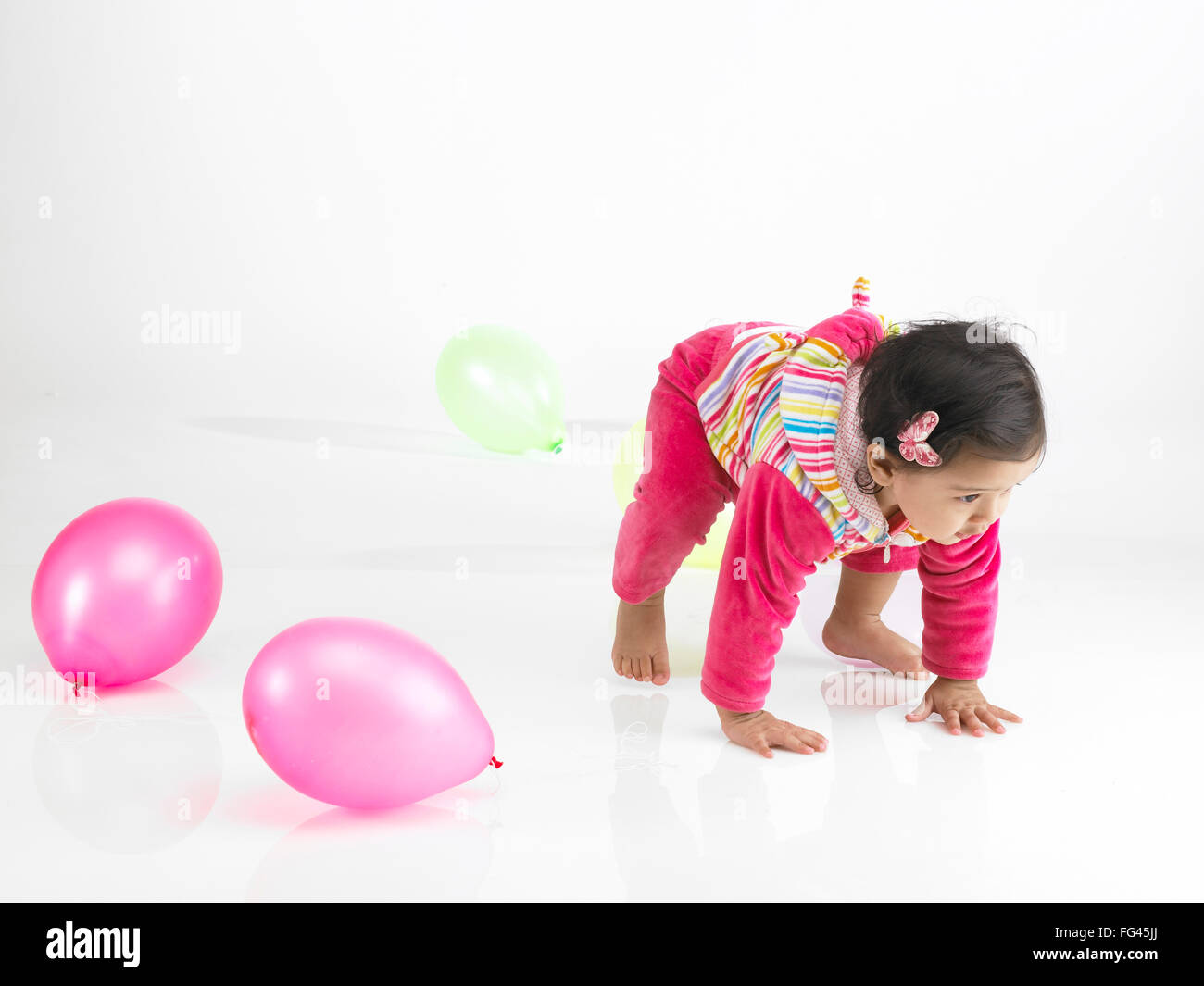 Indian baby girl wearing dress trying to stand up MR#702O Stock Photo ...