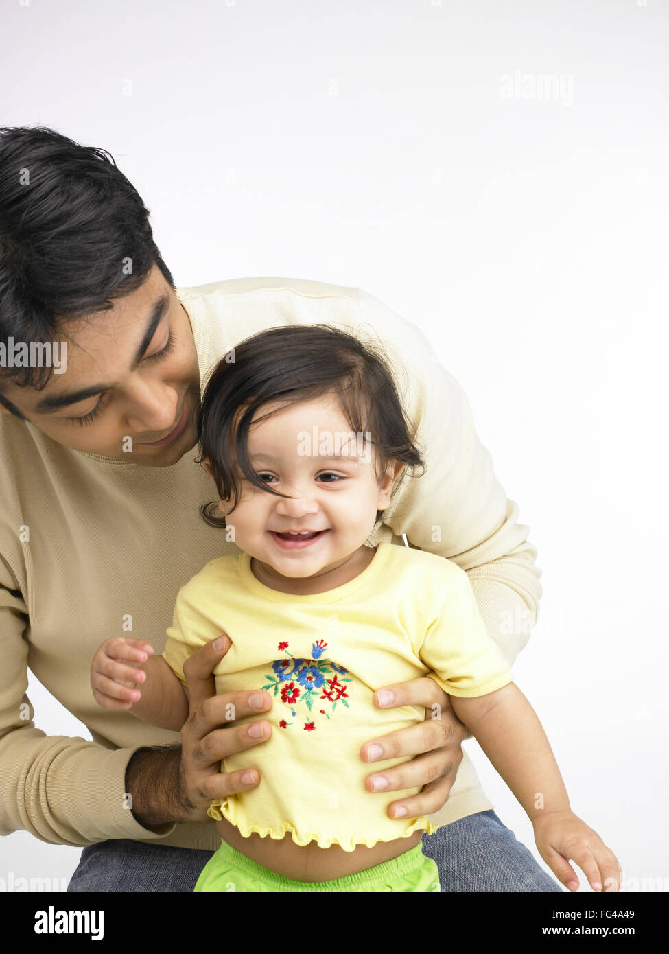 Indian father looking at face of baby girl MR#702O,702A Stock Photo - Alamy
