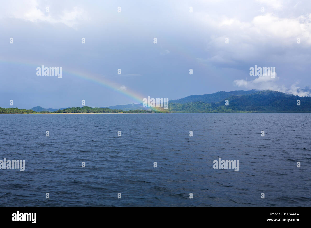 Rainbow over tropical island Stock Photo - Alamy