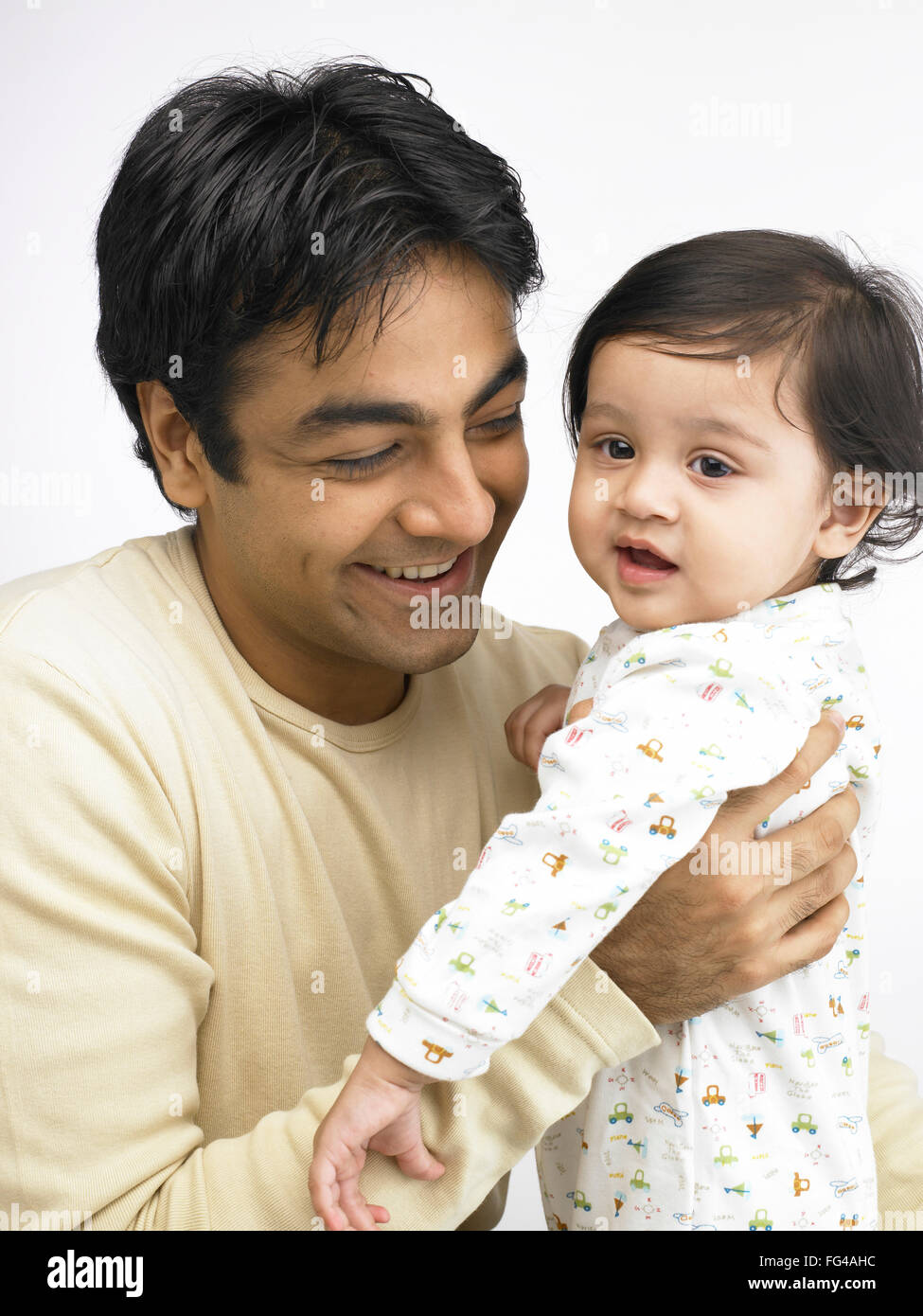 Indian father looking at face of baby girl MR#702O,702A Stock Photo - Alamy