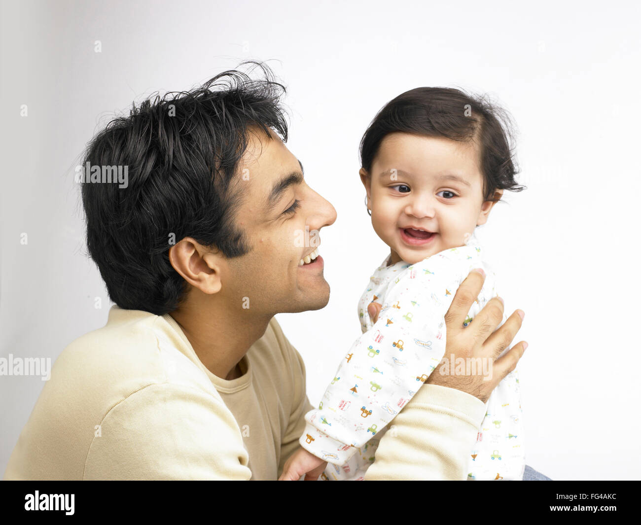 Indian father looking at face of baby girl MR#702O,702A Stock Photo - Alamy