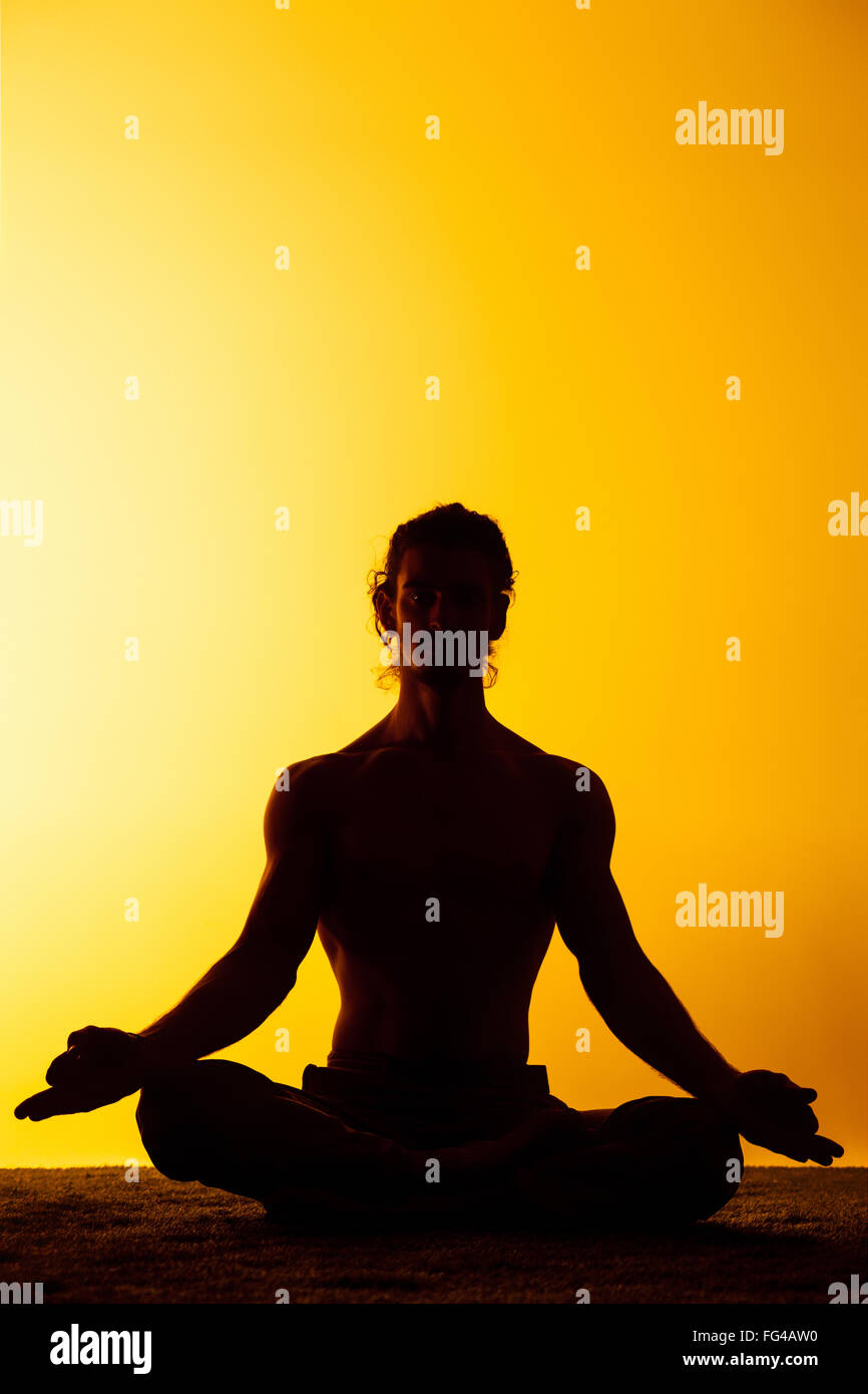 The man practicing yoga in the sunset light Stock Photo - Alamy