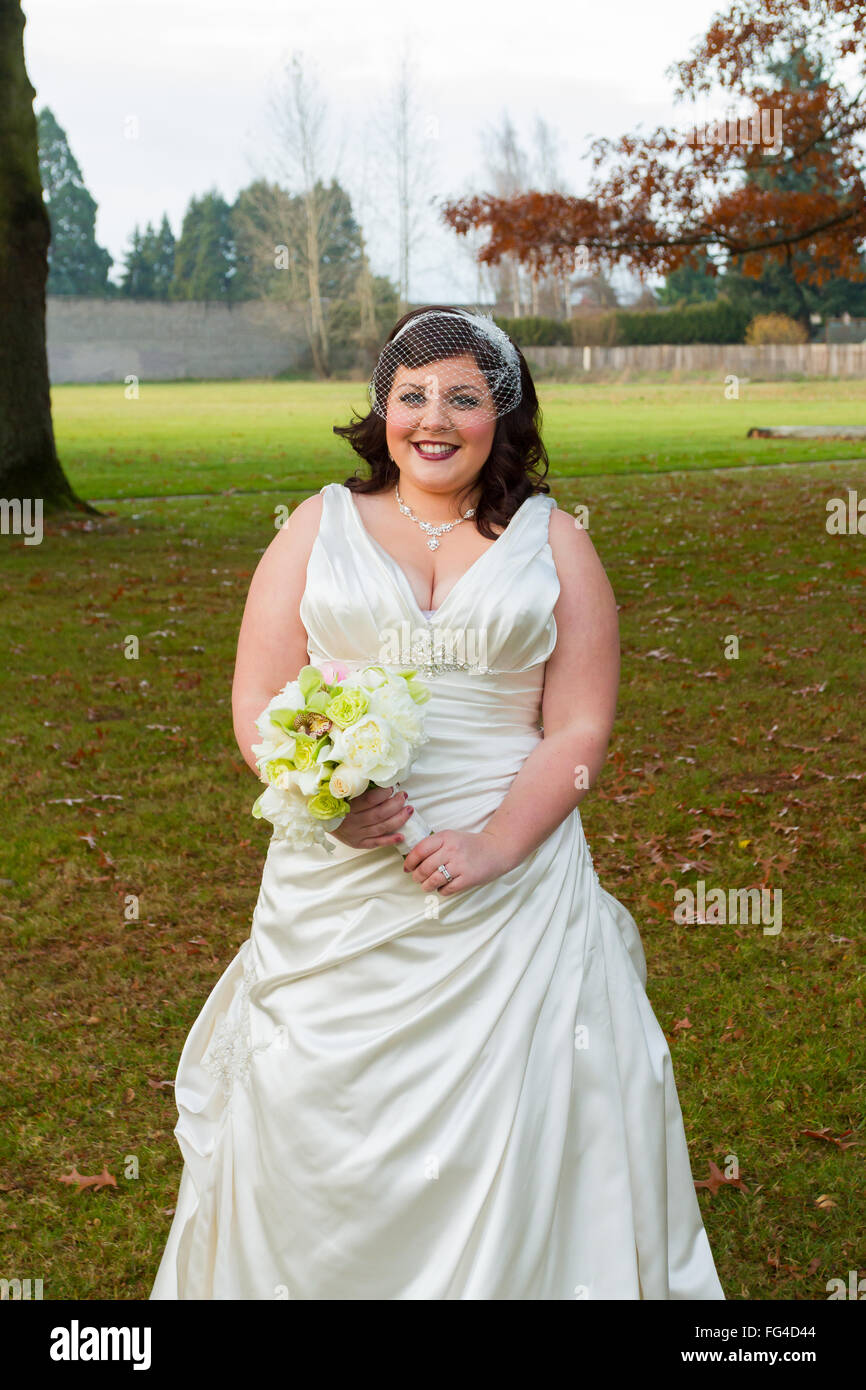Bride on her wedding day posing along for a portrait outdoors in Oregon ...