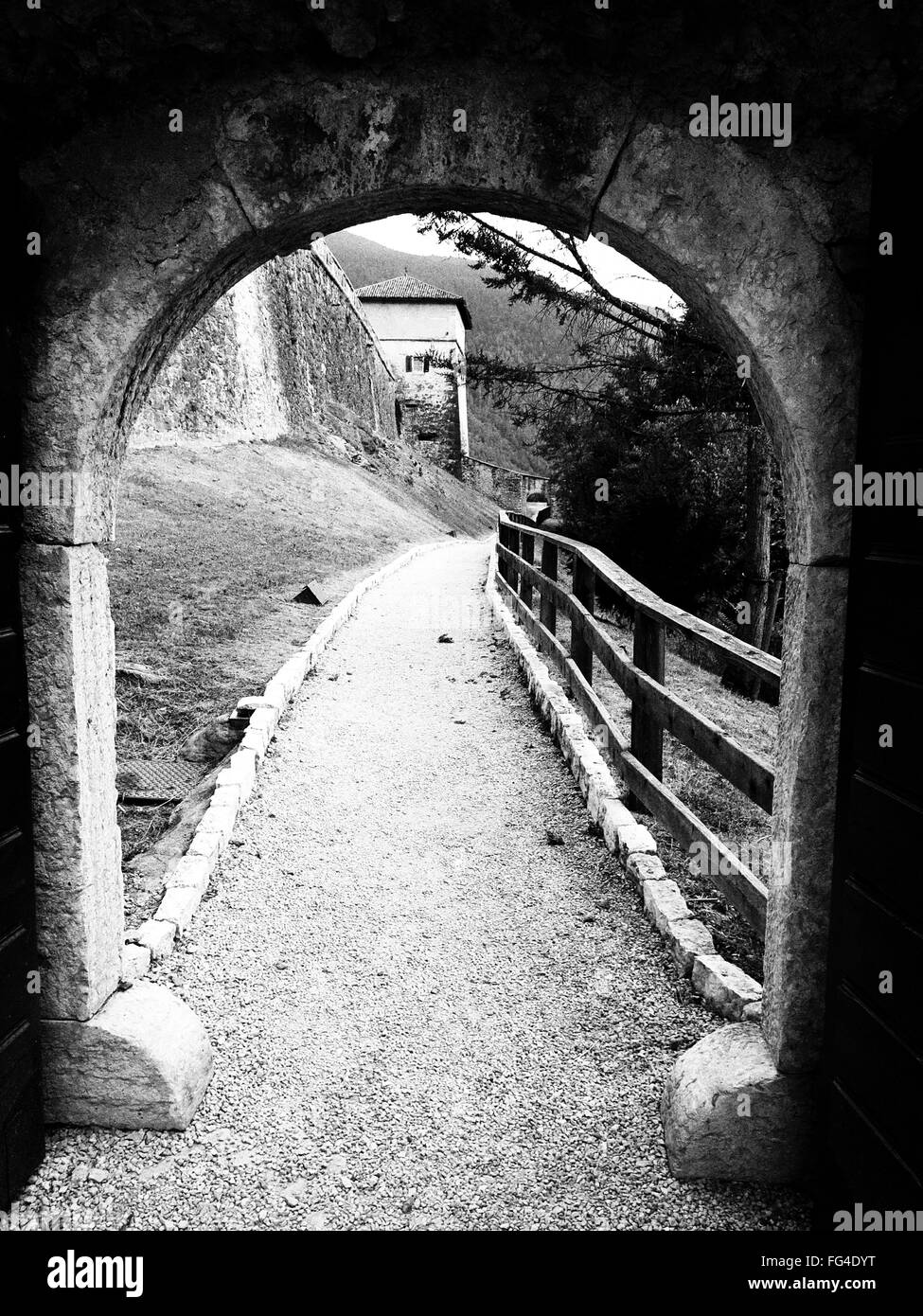 View Of Narrow Pathway Through Arched Wall Stock Photo - Alamy
