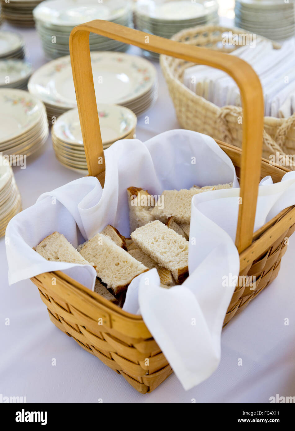 Bread in basket and stacks of plates on table Stock Photo - Alamy