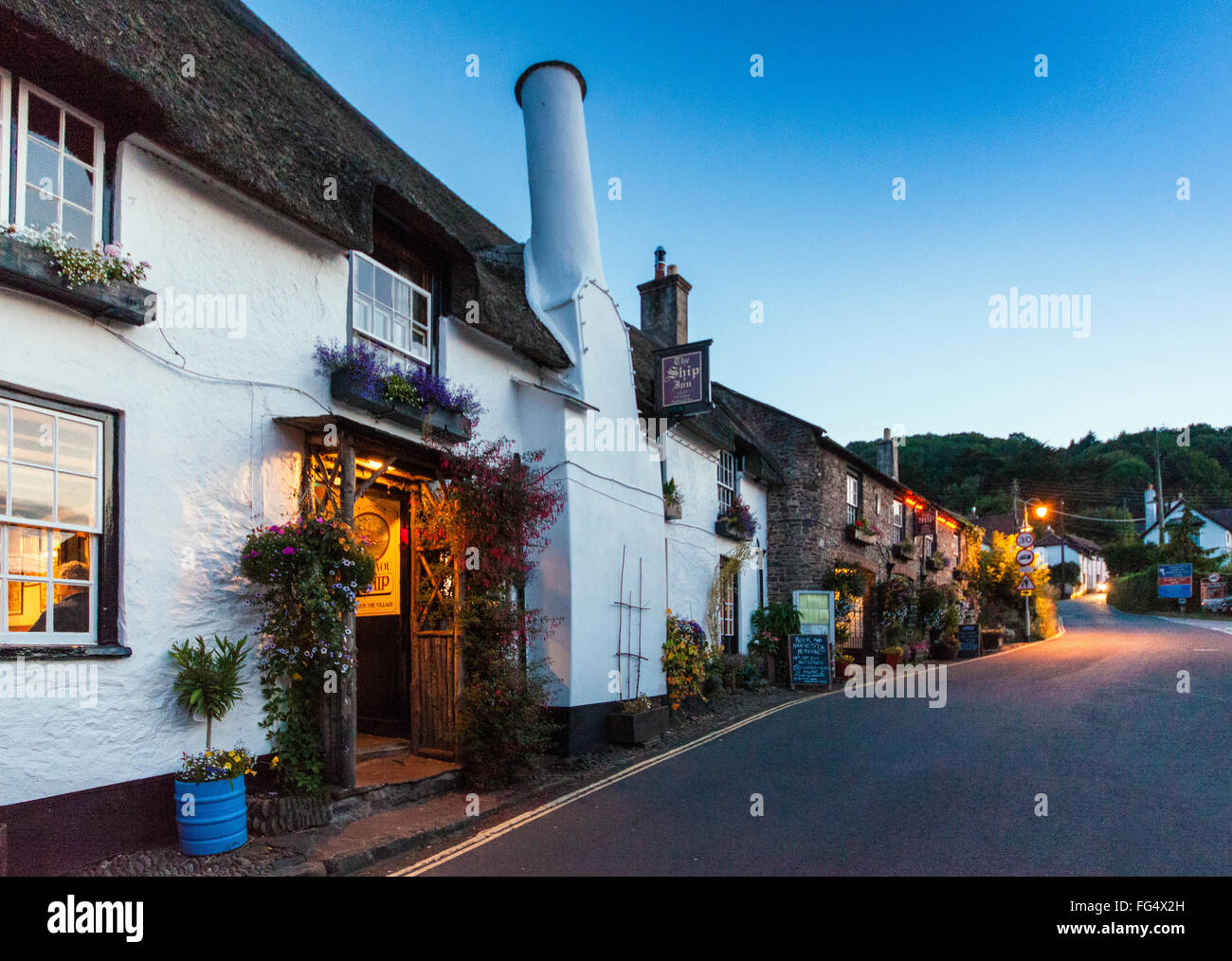 Porlock Somerset, Hight Street, at dusk with blue sky. Houses and shops ...