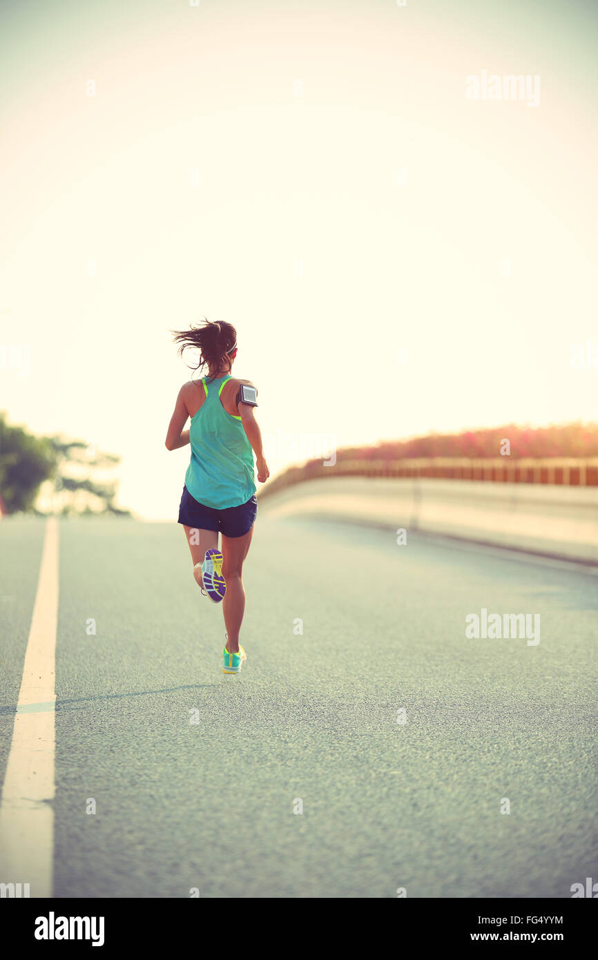 young woman runner running on city bridge road Stock Photo - Alamy